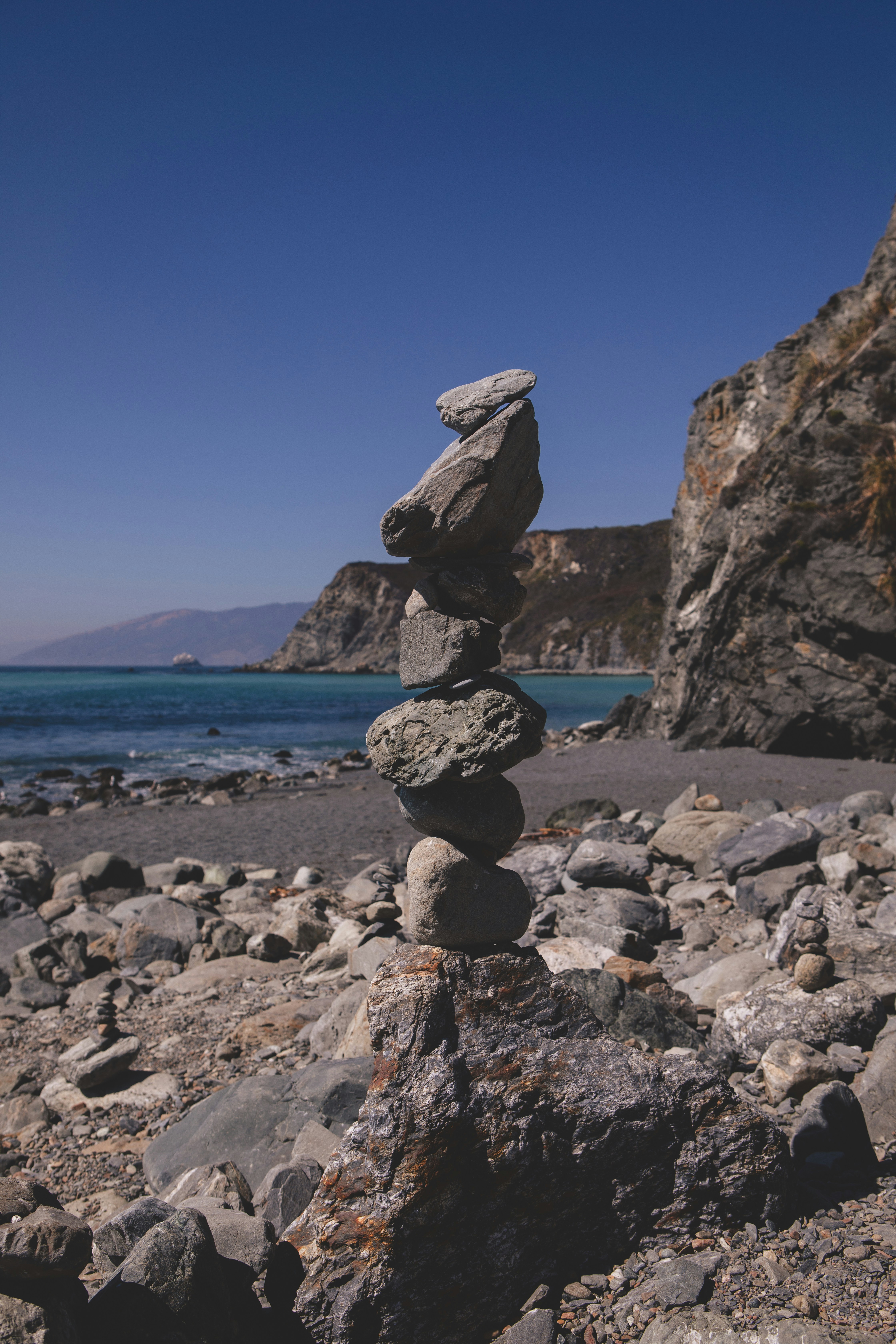 A stack of rocks sitting on top of a rocky beach photo – Free Ocean ...