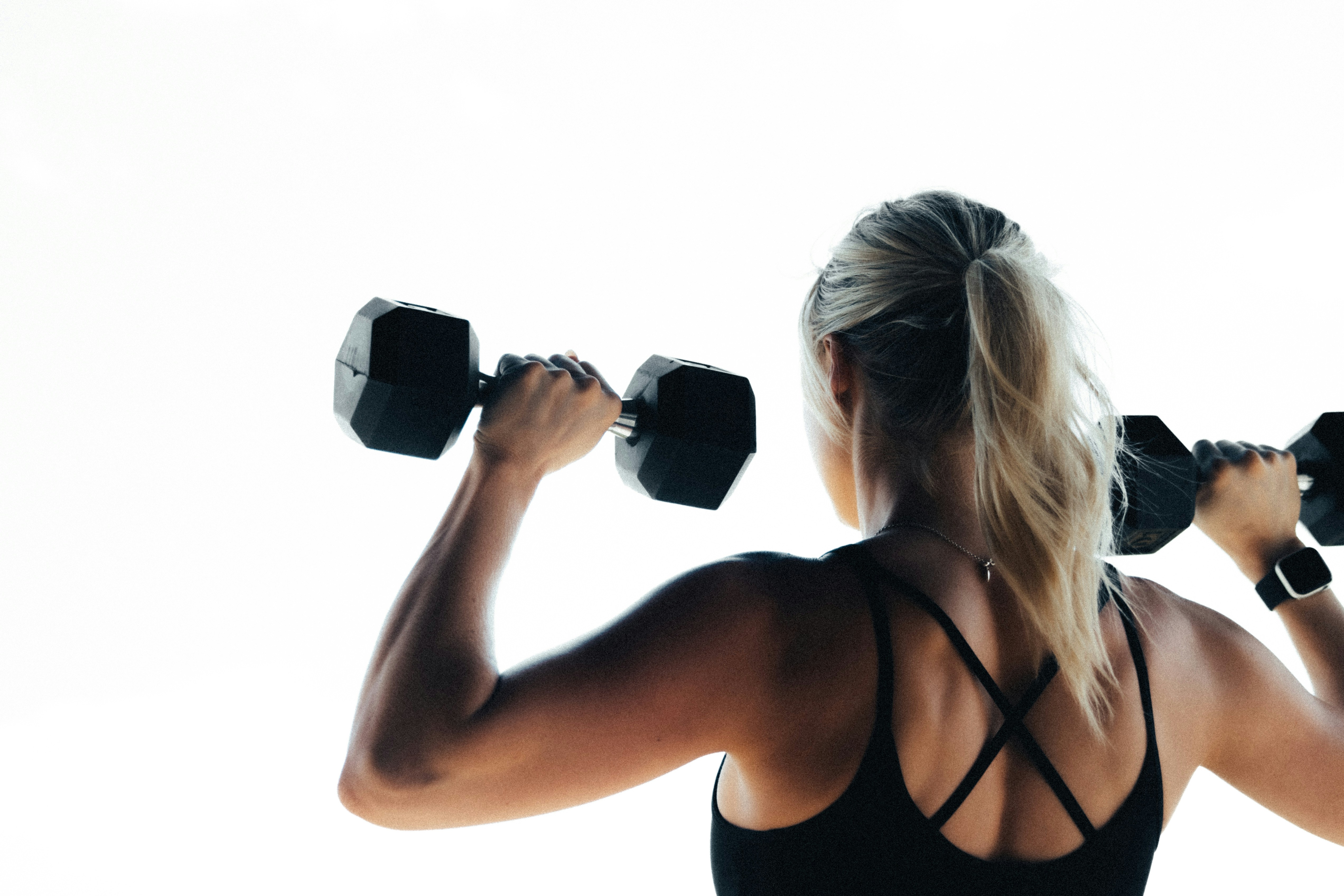 A woman holding two dumbs in her hands photo – Free Adult Image on Unsplash