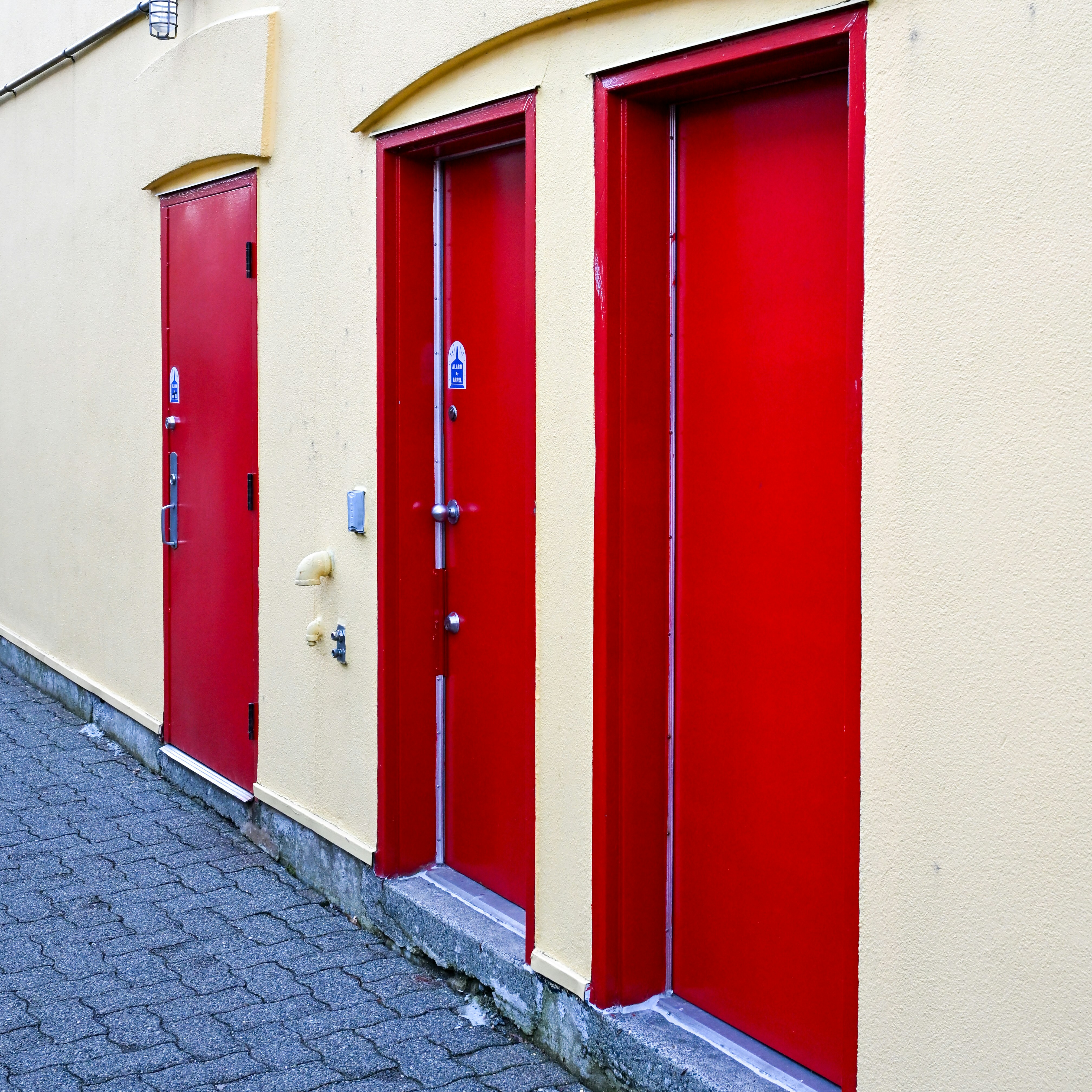 Crimson Doors Line Up on a Sunny Yellow Wall