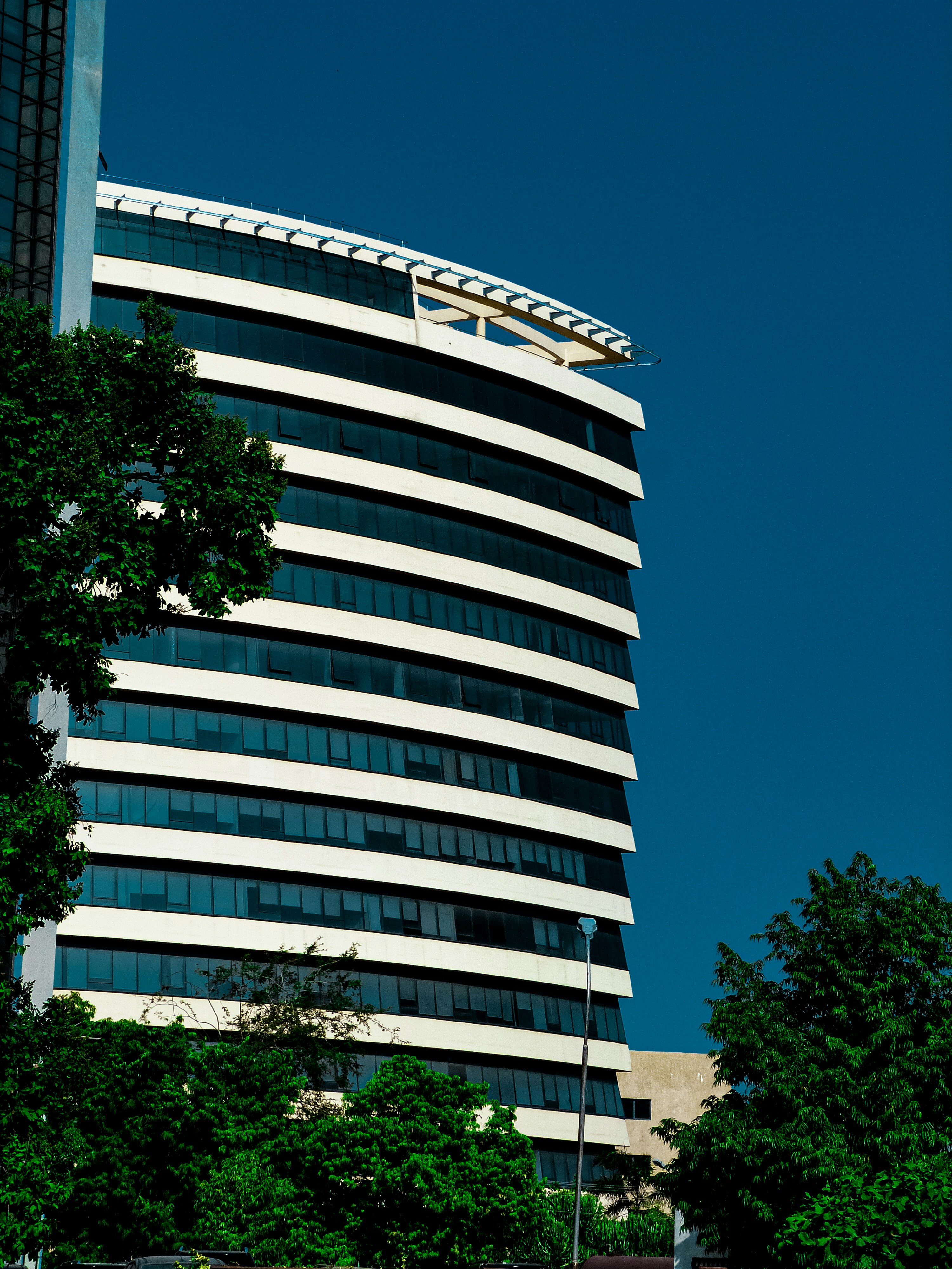 Crescent of Glass: The Curved Tower Against a Deep Blue Sky