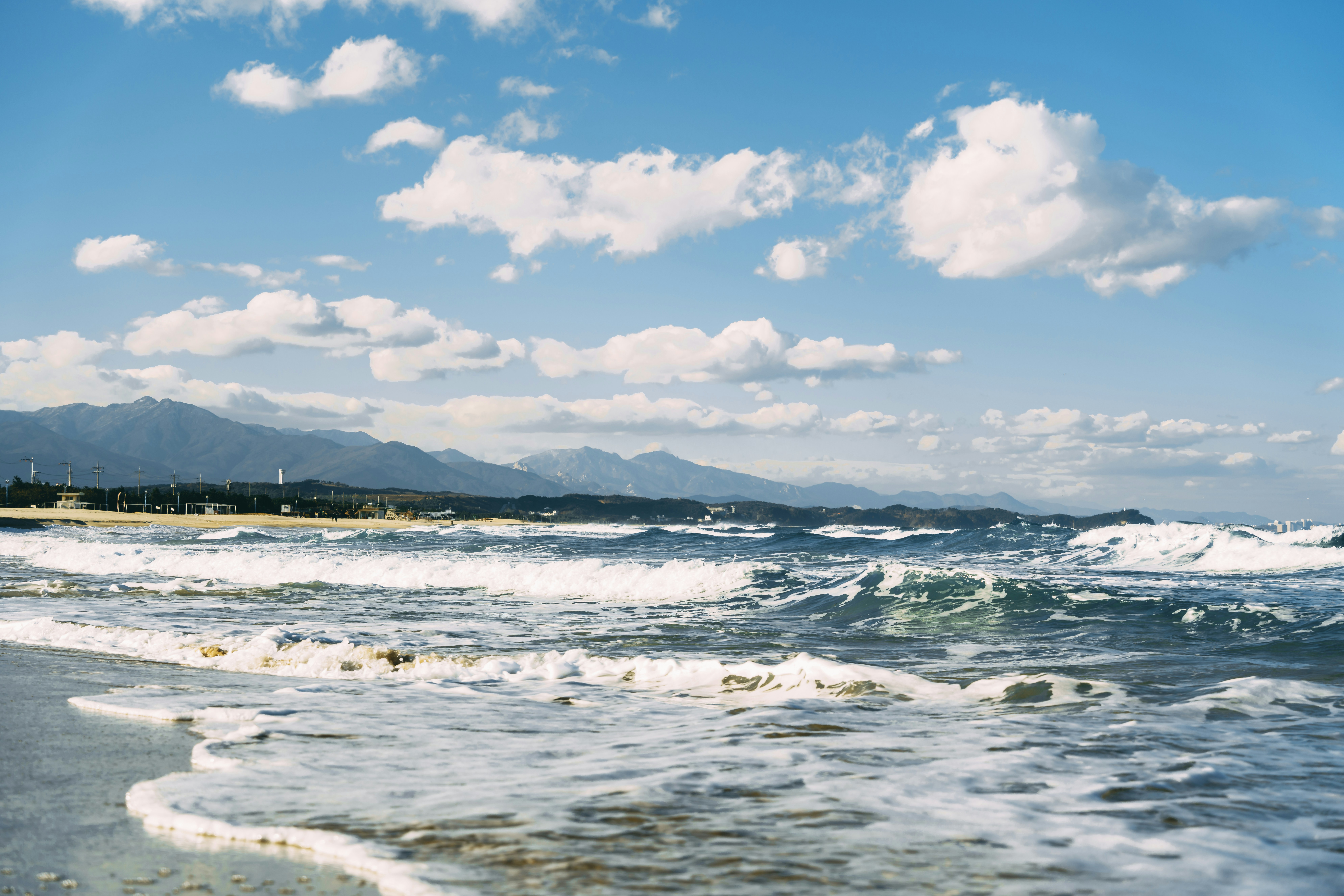 A view of a beach with waves coming in to shore photo – Free Ocean ...