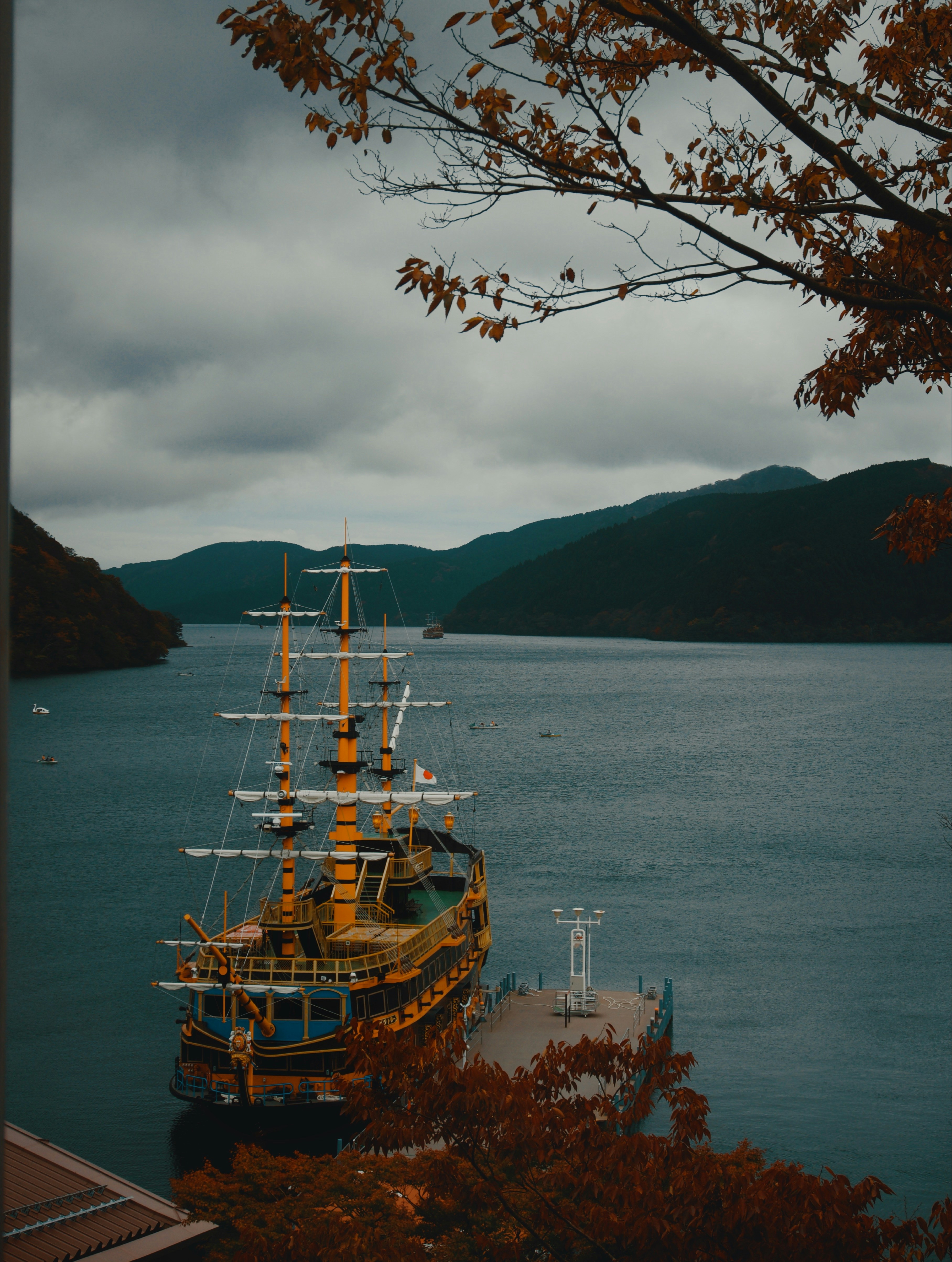Autumn Harbor: A Yellow-Clad Clipper Anchored in Quiet Fjord Waters