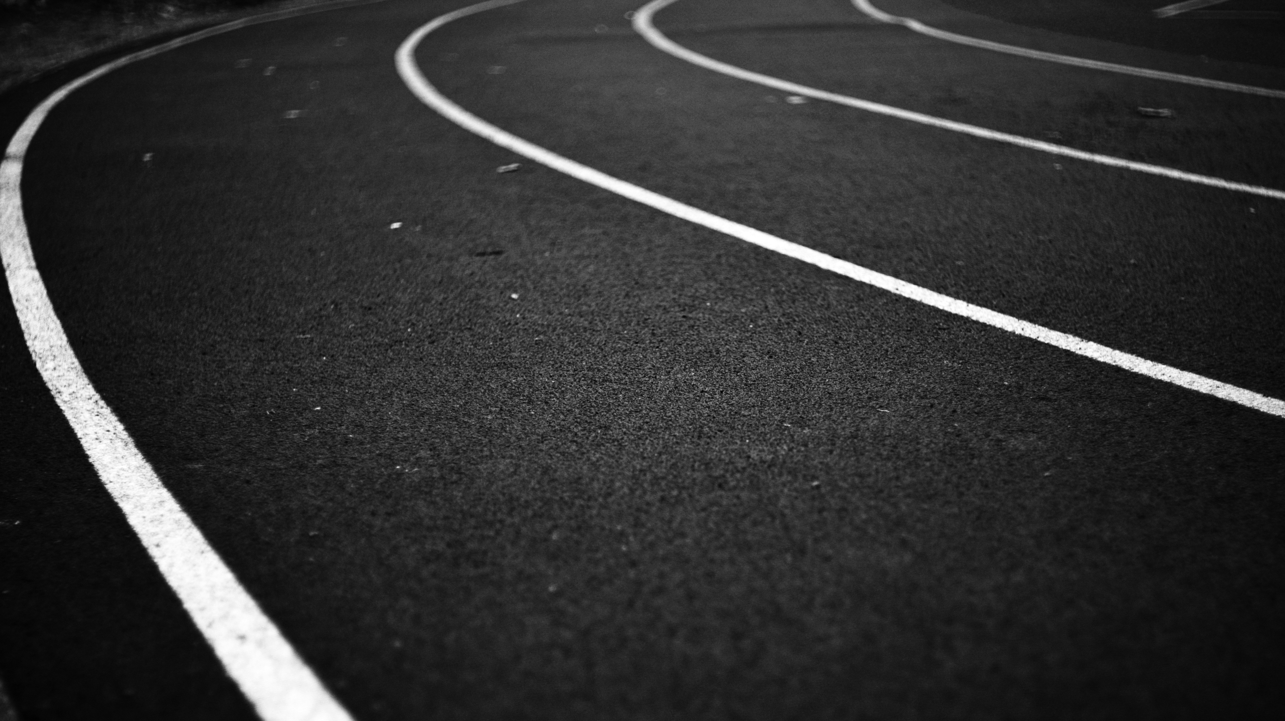 A black and white photo of a curved road