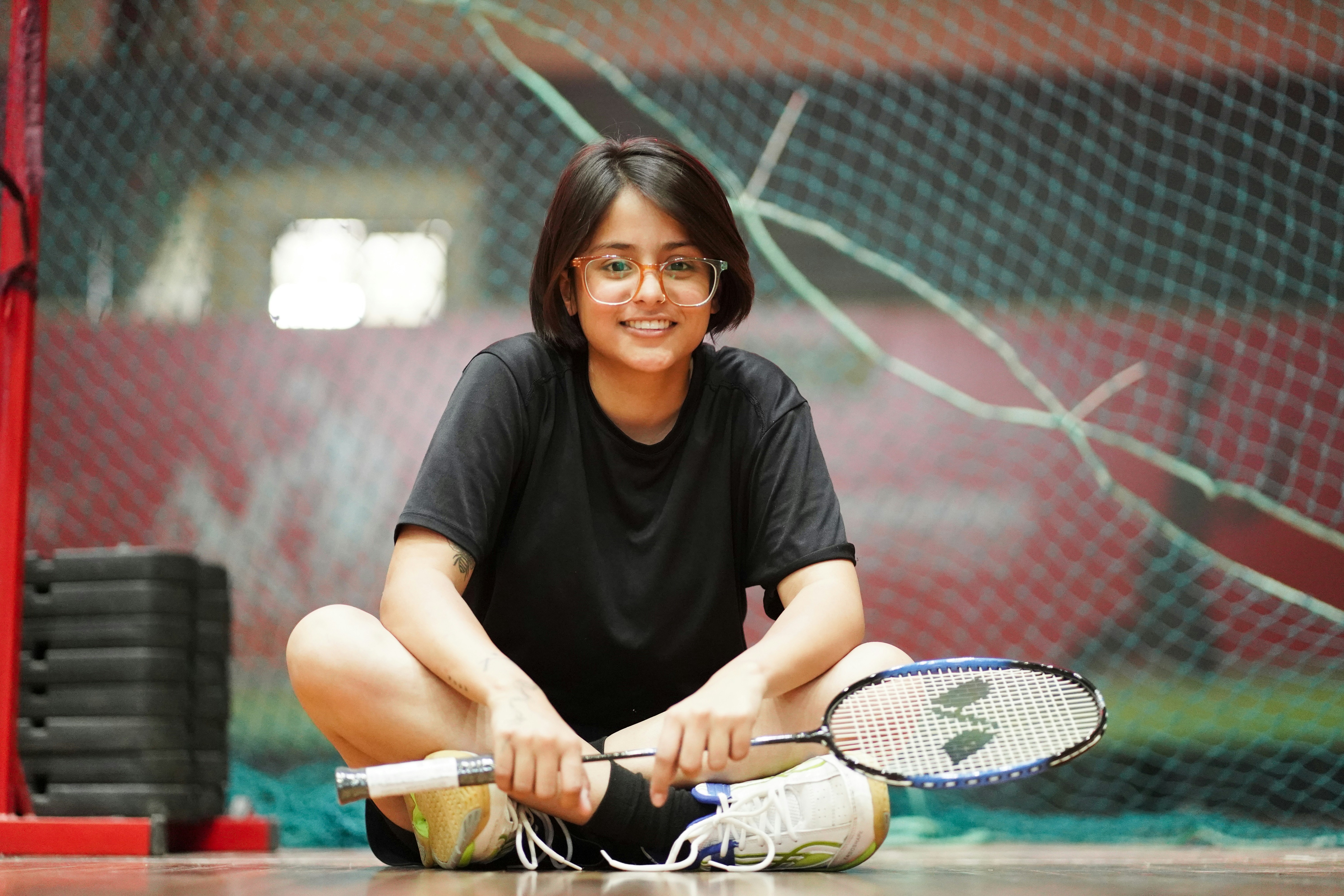 Grounded Focus: A Quiet Portrait of a Badminton Player by the Net