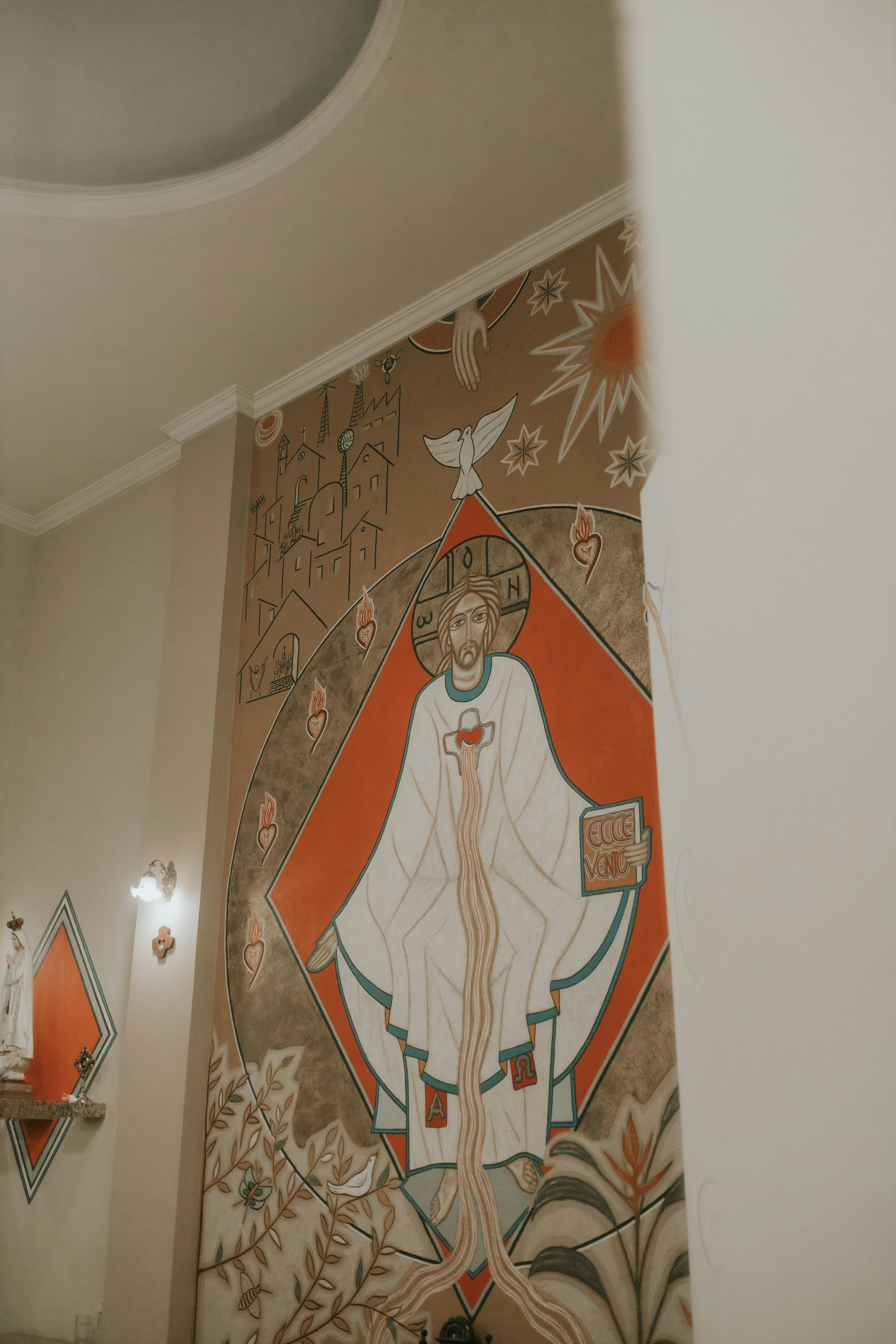 A vibrant mural depicting a religious figure with flowing robes, surrounded by symbolic elements and a serene atmosphere.