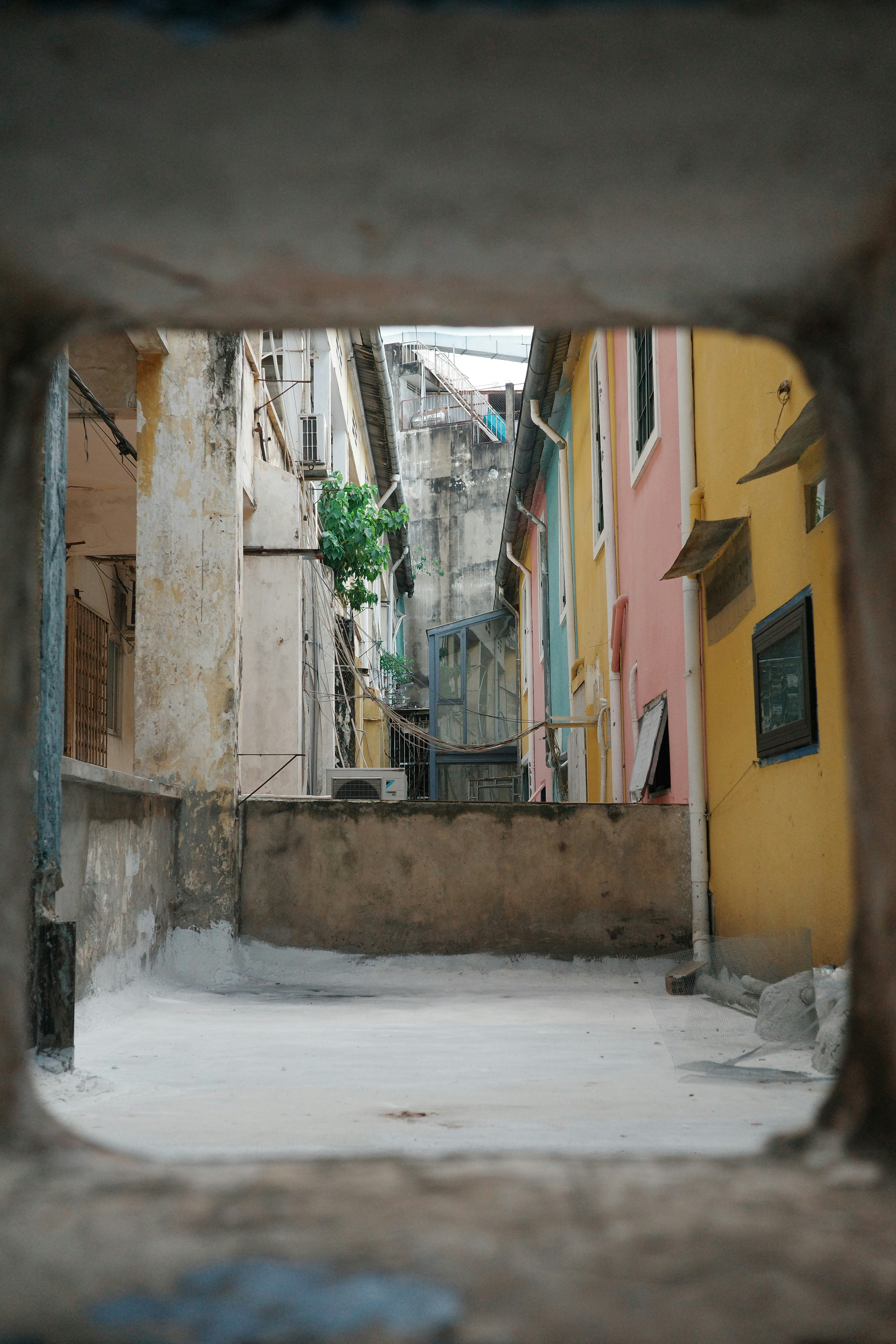 A view of a street through a hole in a wall photo – Free Ho chi minh ...