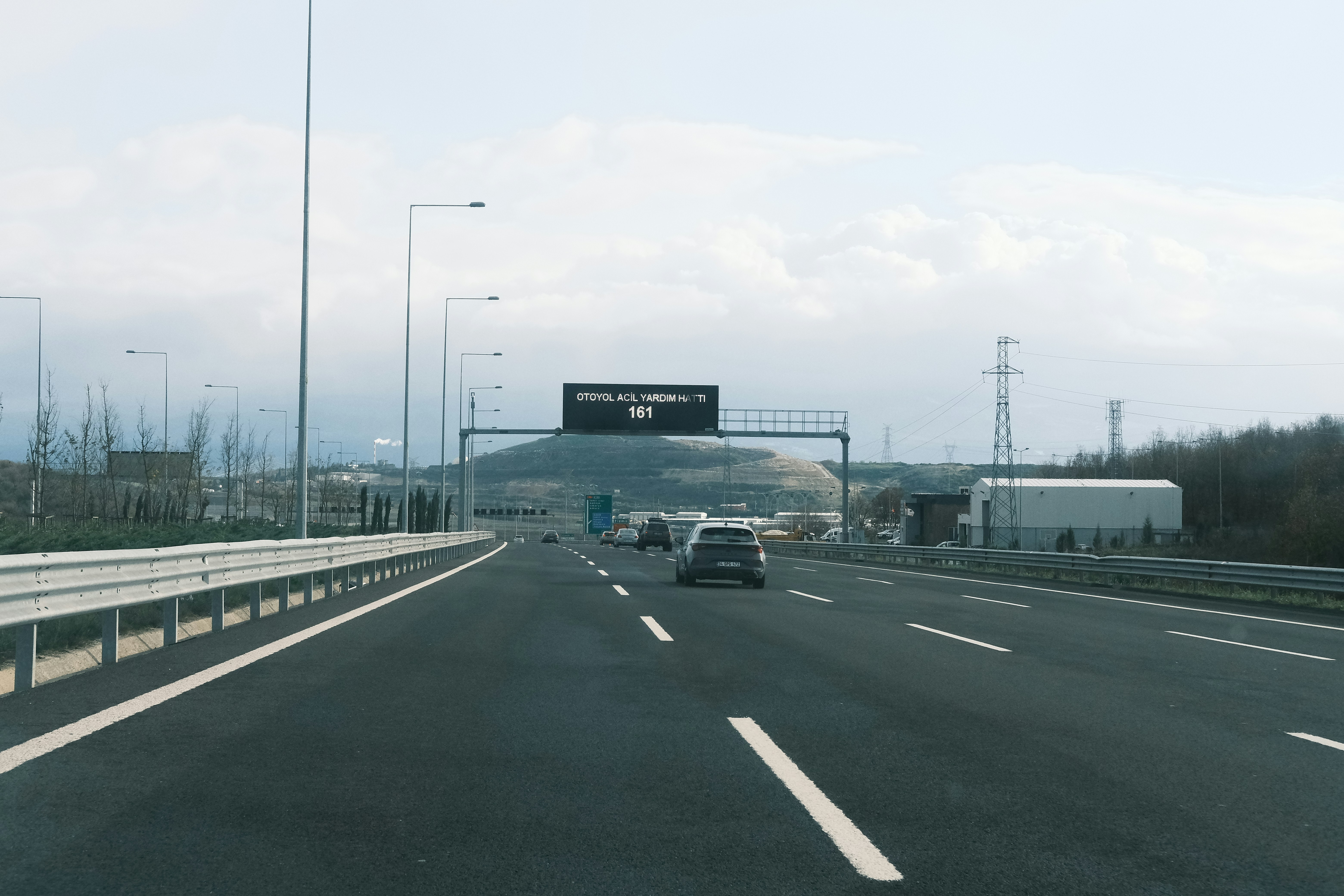 Un'auto che percorre un'autostrada accanto a un cartello autostradale ...
