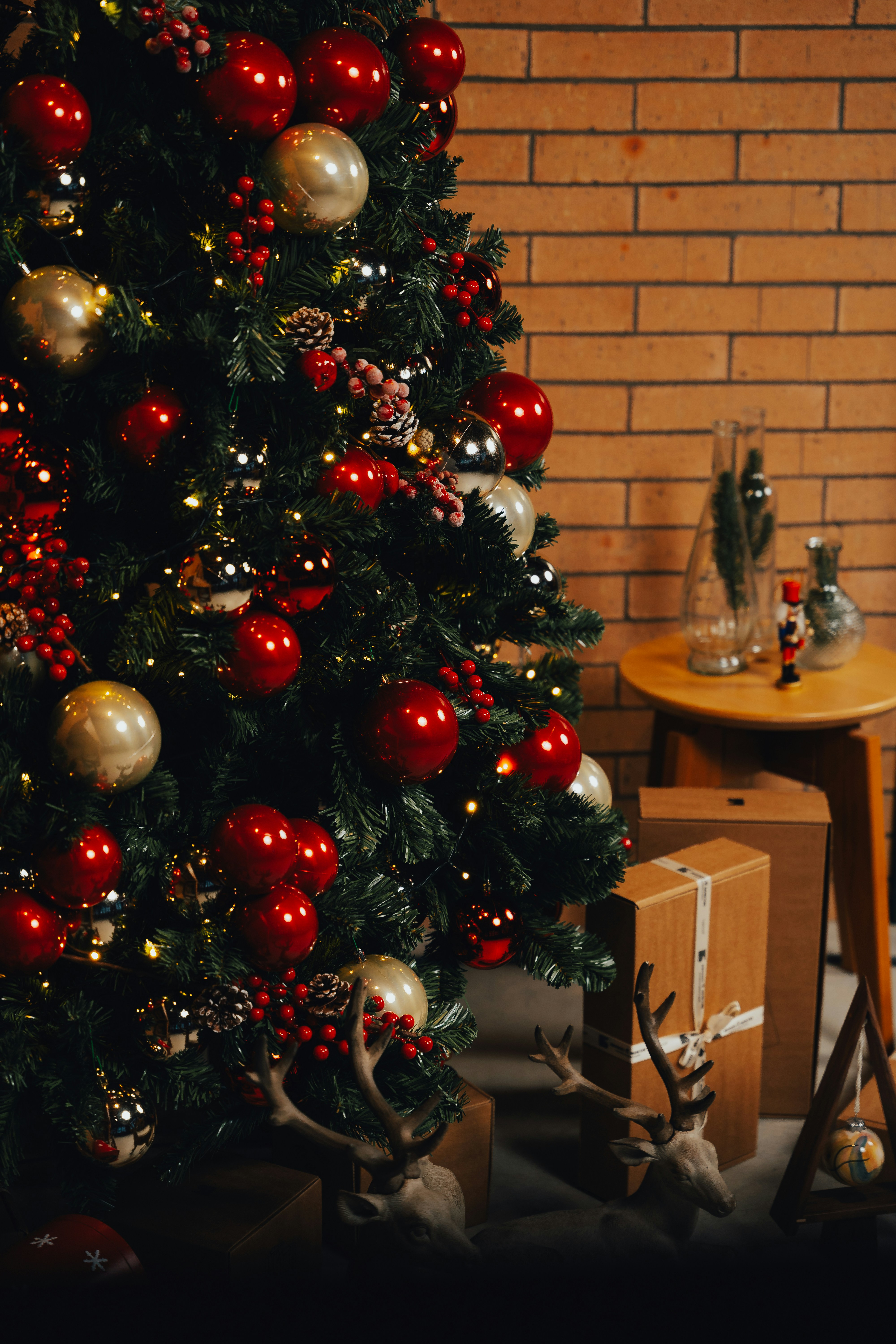 Crimson Ornaments and Golden Glow: A Christmas Tree Portrait by a Cozy Brick Wall