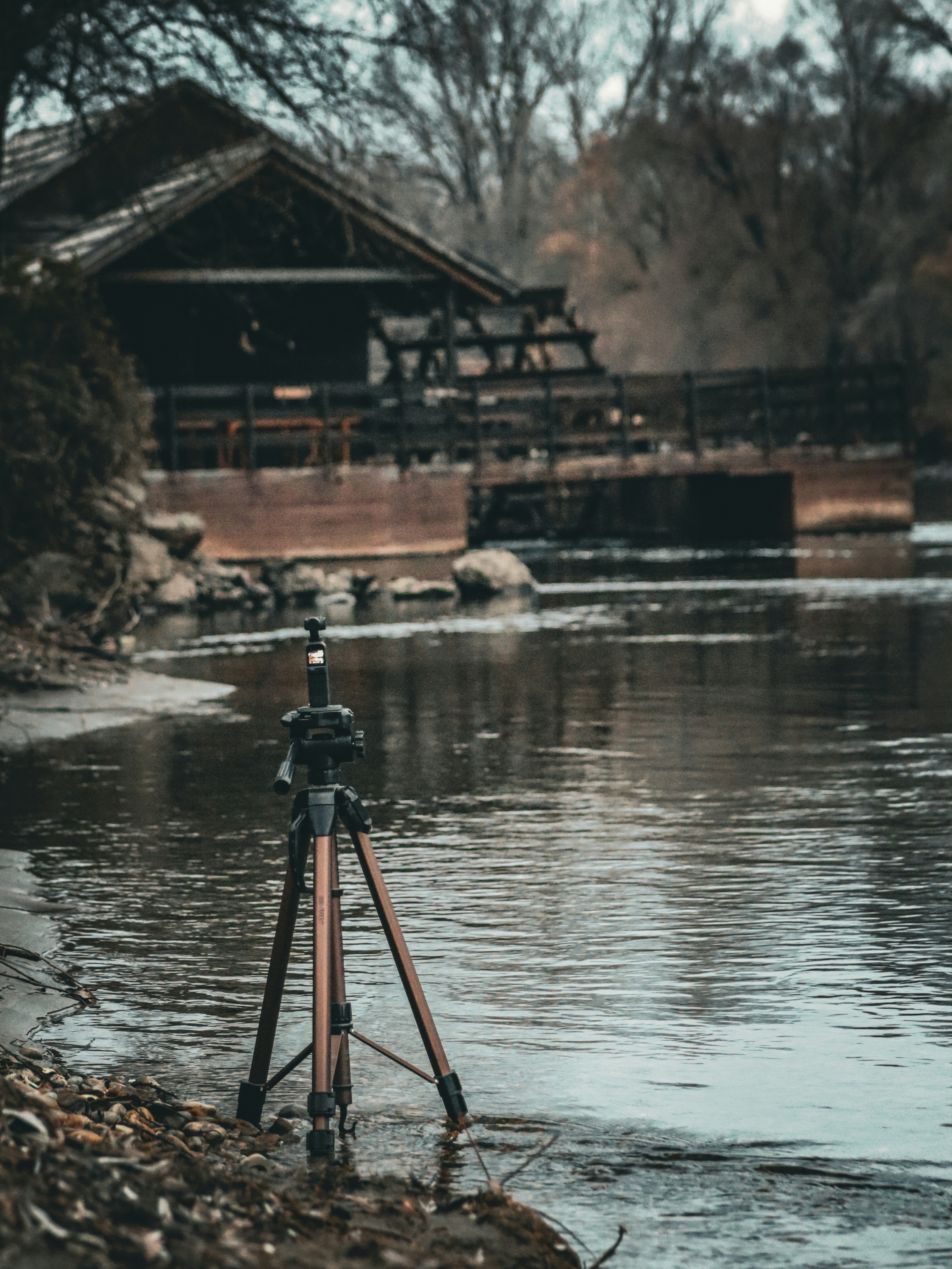 Tripod Beside the Still River Framing a Quiet Landscape