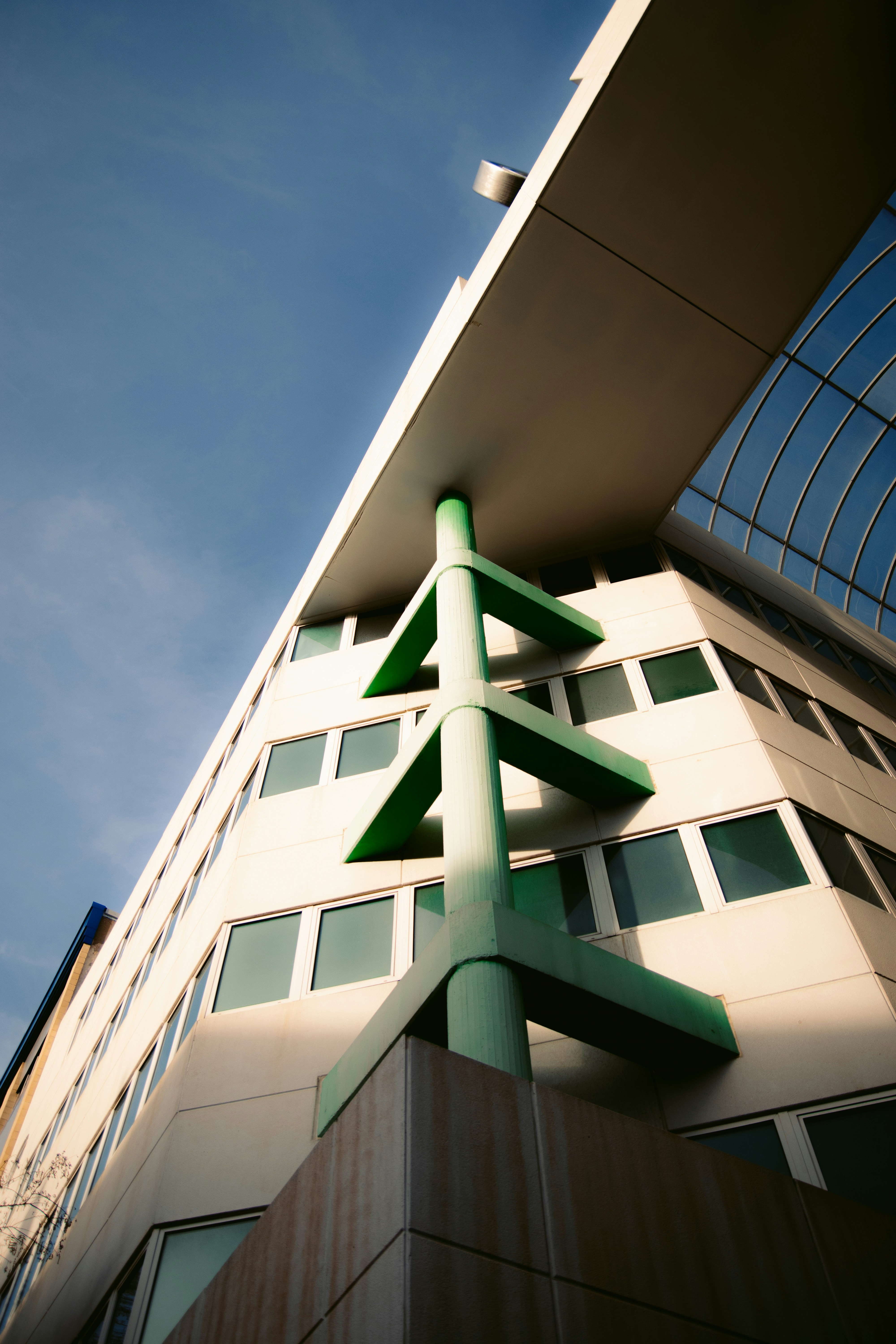 A tall building with a green arrow on the side of it photo – Free ...