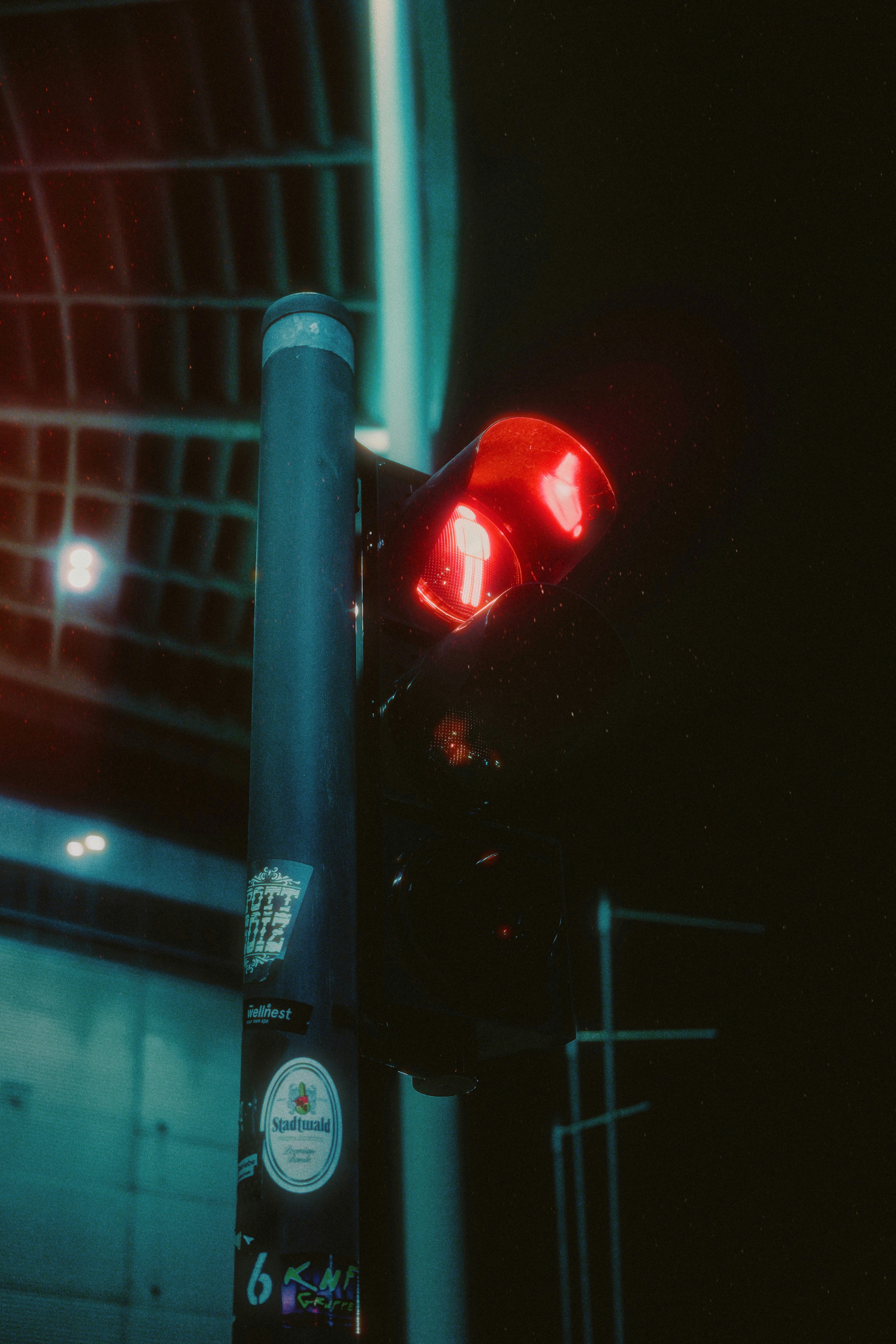Red Signal at Neon Edge: Night Glow on a Weathered Street Pole