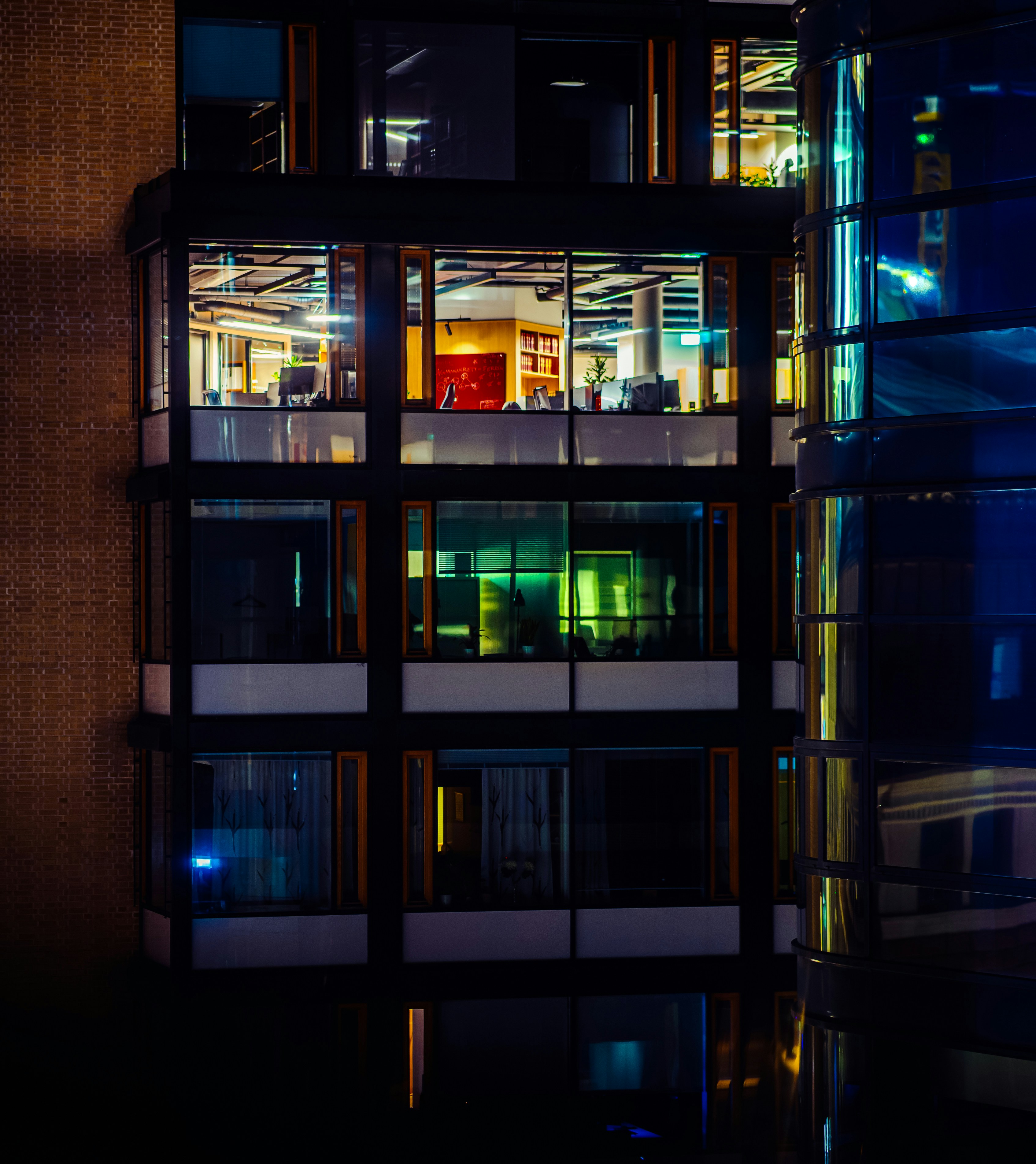 A tall building with lots of windows lit up at night photo – Free ...