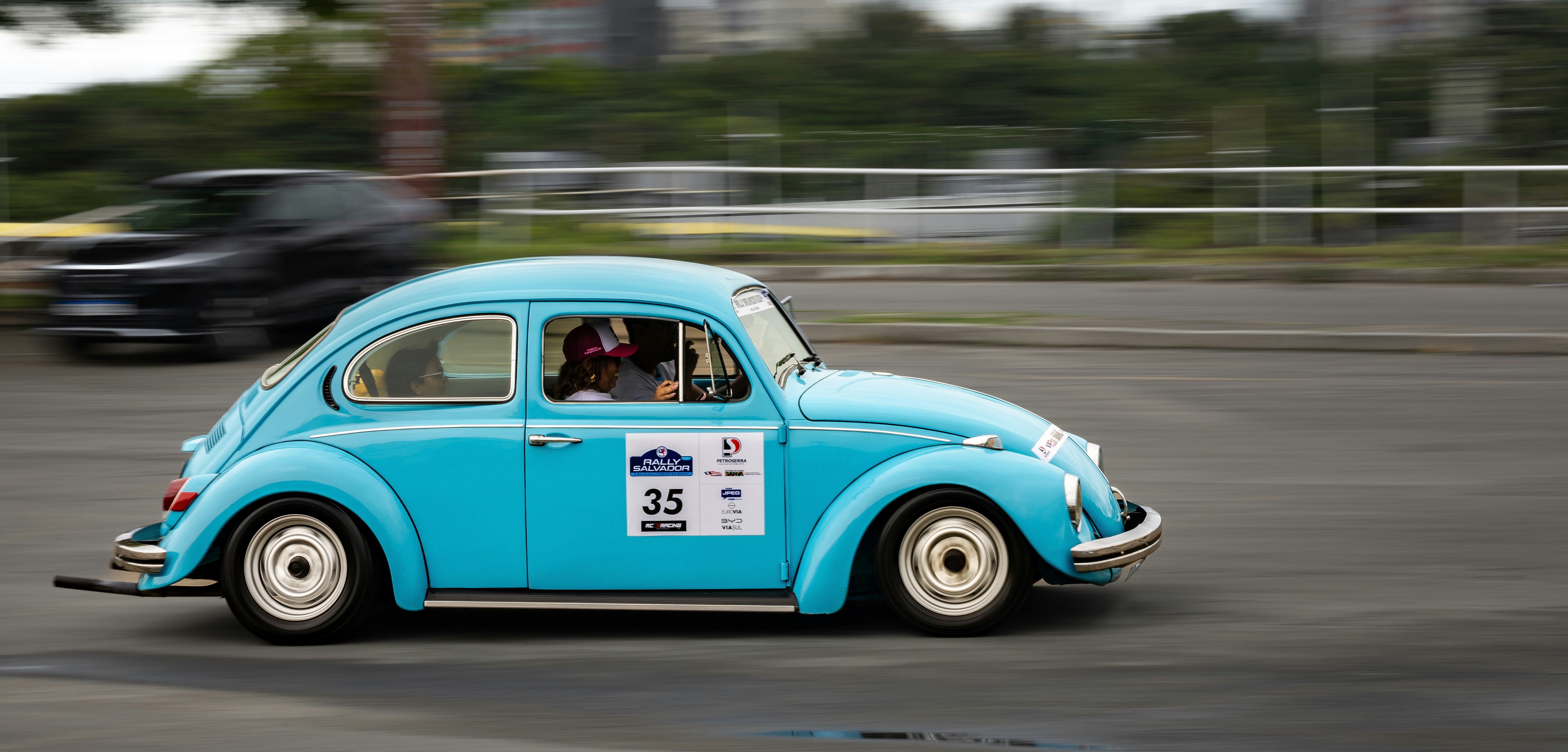 Azure Beetle Rally: a vintage VW carving through motion on urban pavement