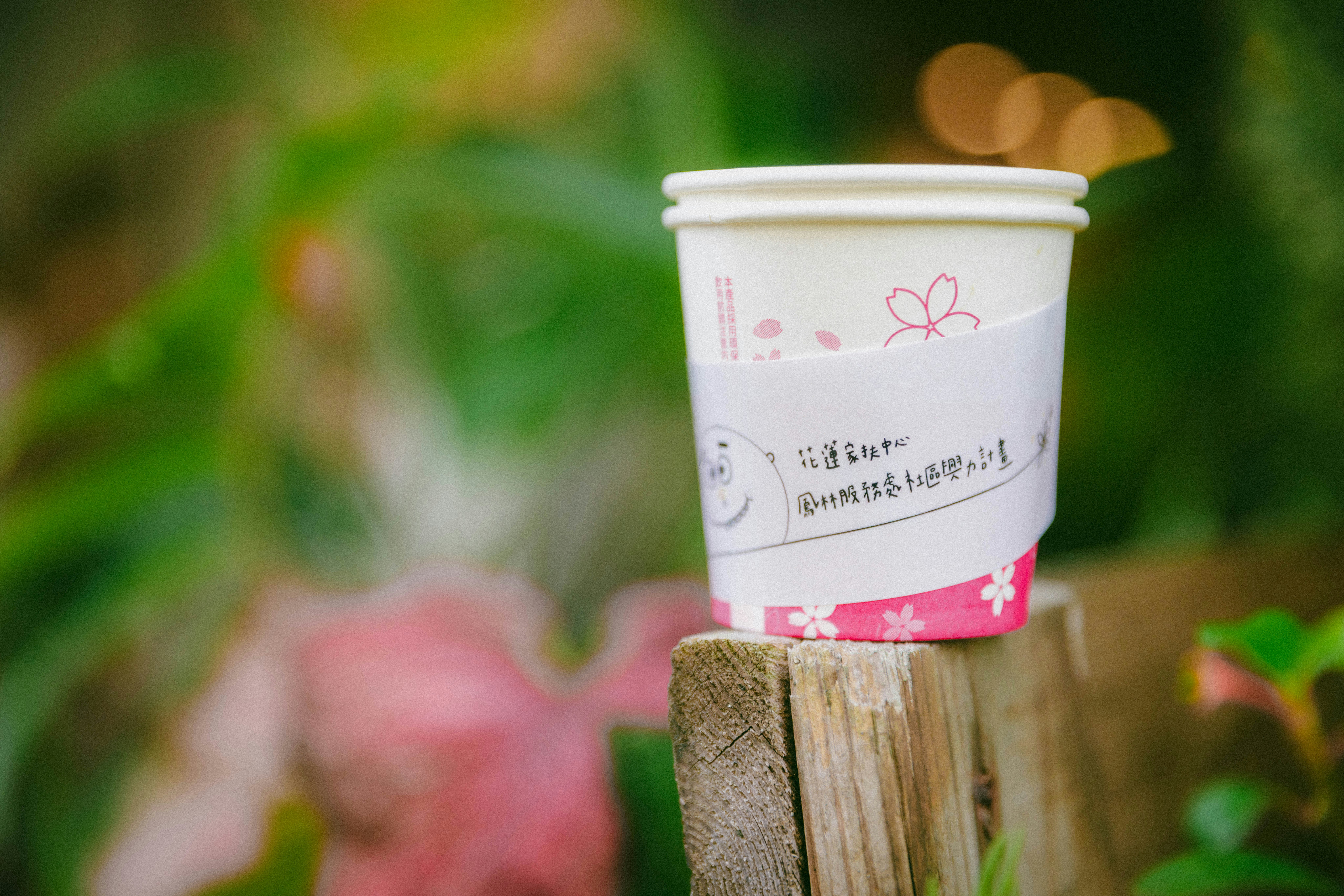A cup of coffee sitting on top of a wooden post