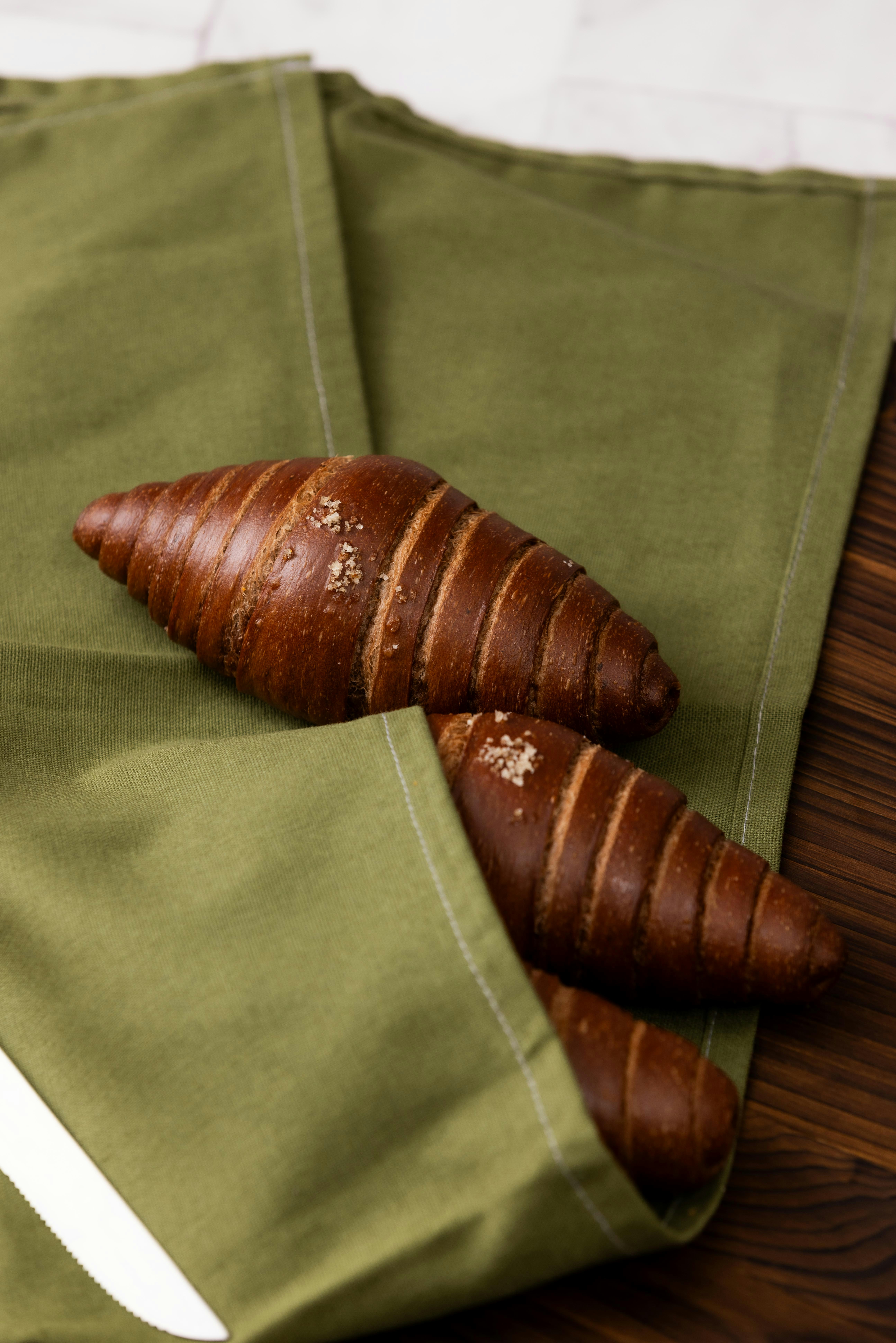 Two croissants are wrapped in a green napkin photo – Free Food Image on ...