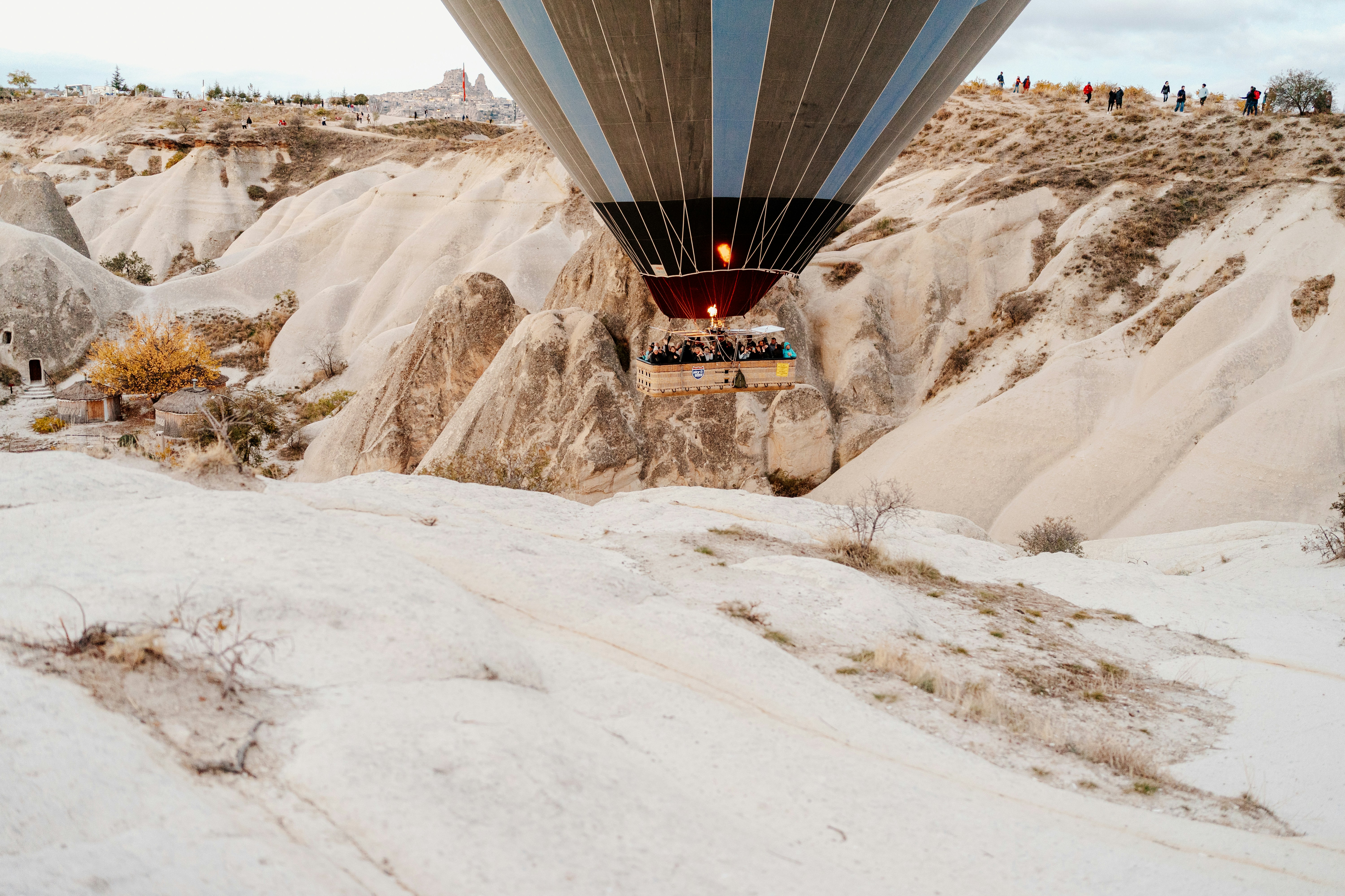 Basket Beneath the Burner: A Balloon Drifts Over a Pale Canyon Rim