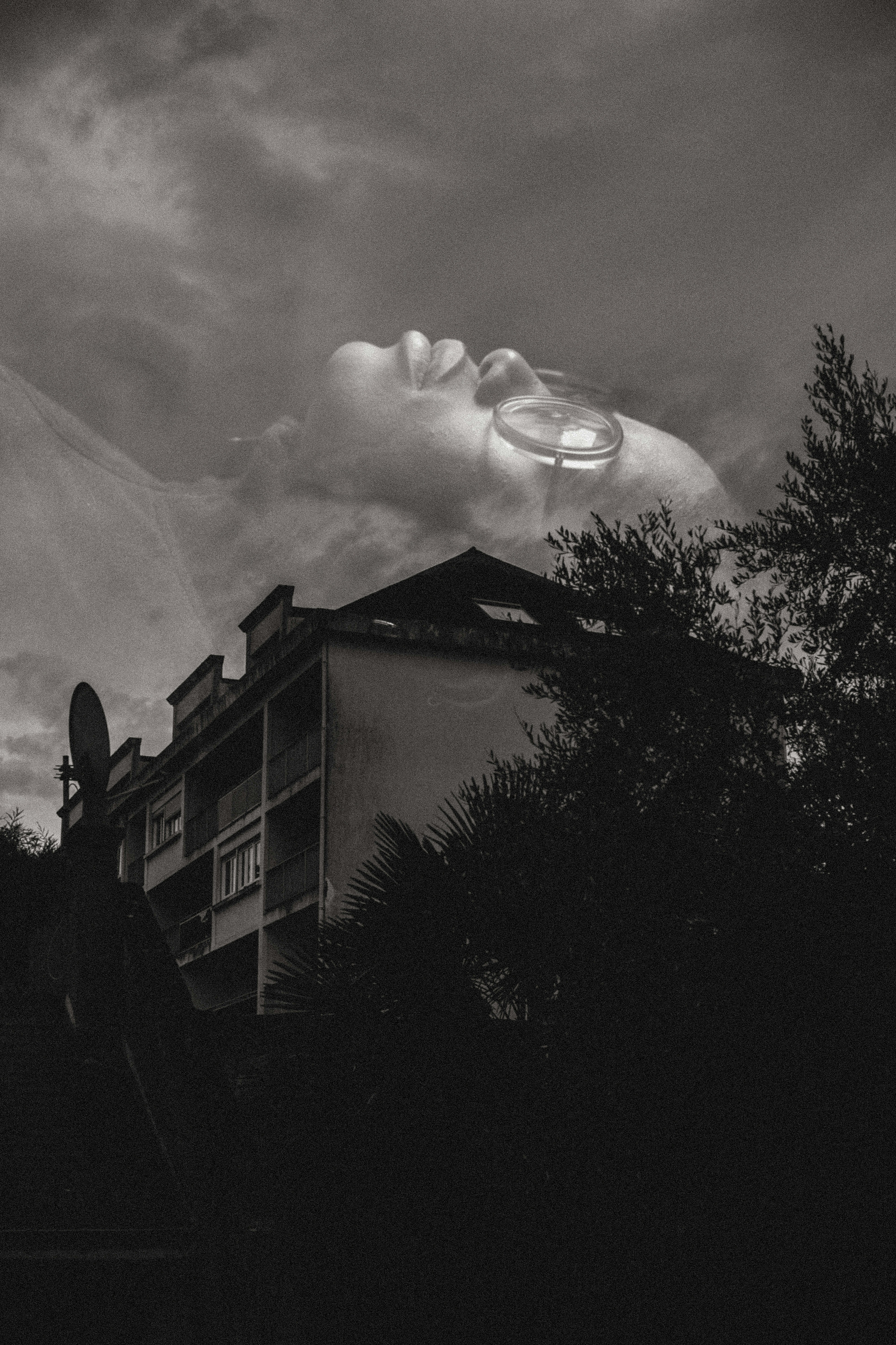 A black and white photo of a woman's face in the sky