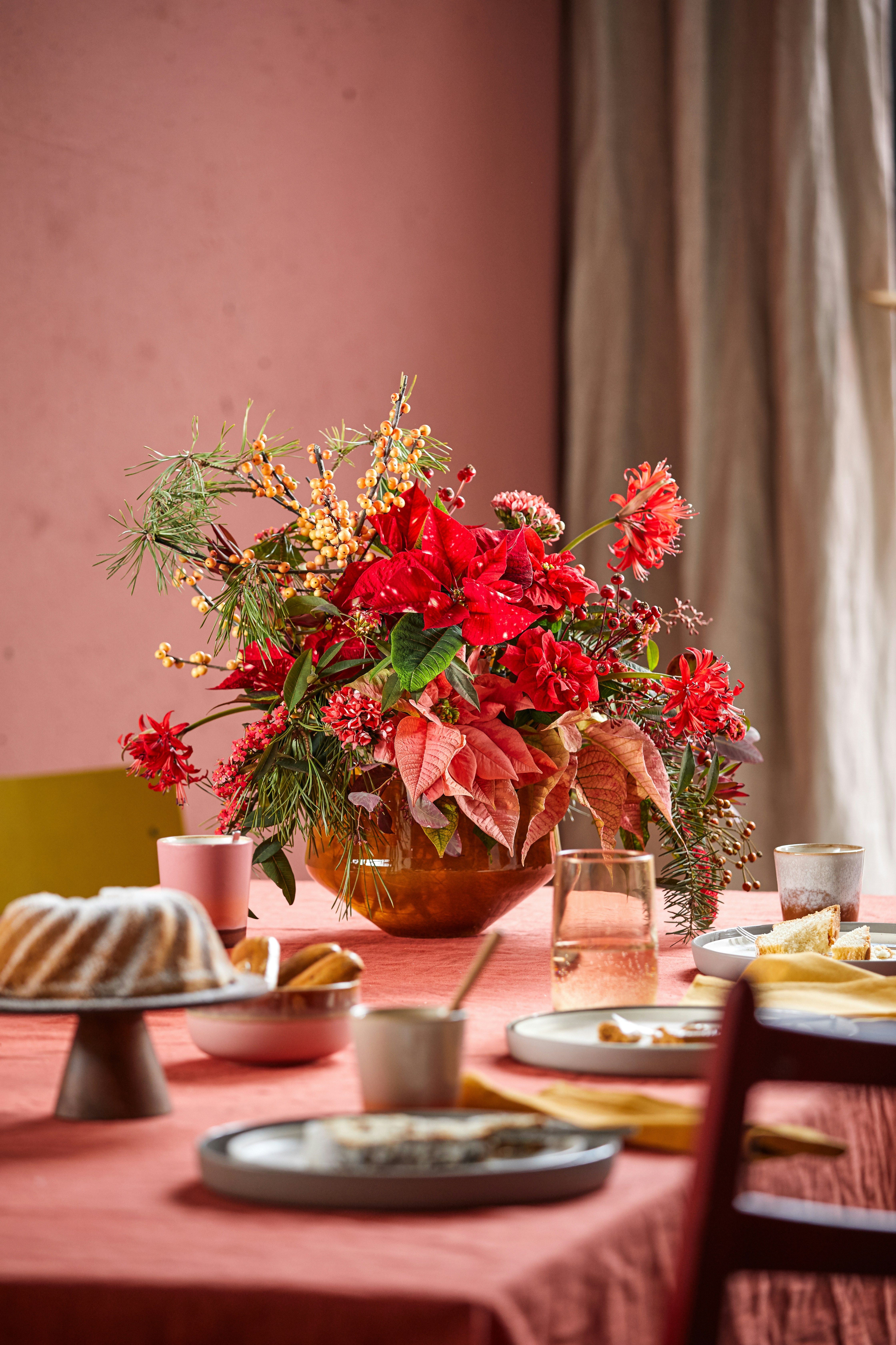 Une table avec une nappe rouge et un vase de fleurs photo – Image ...