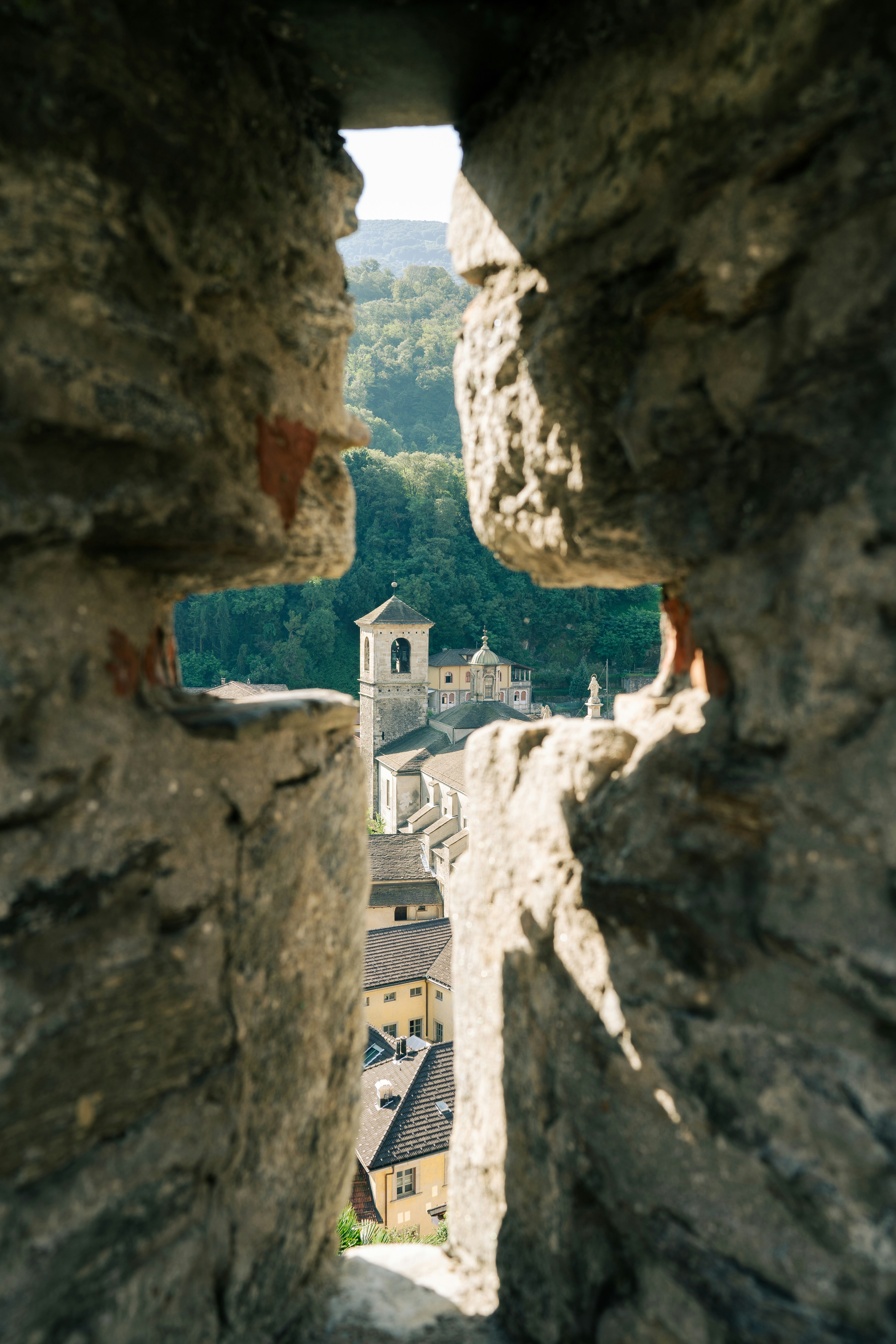 A view of a castle through a hole in a stone wall photo – Free ...