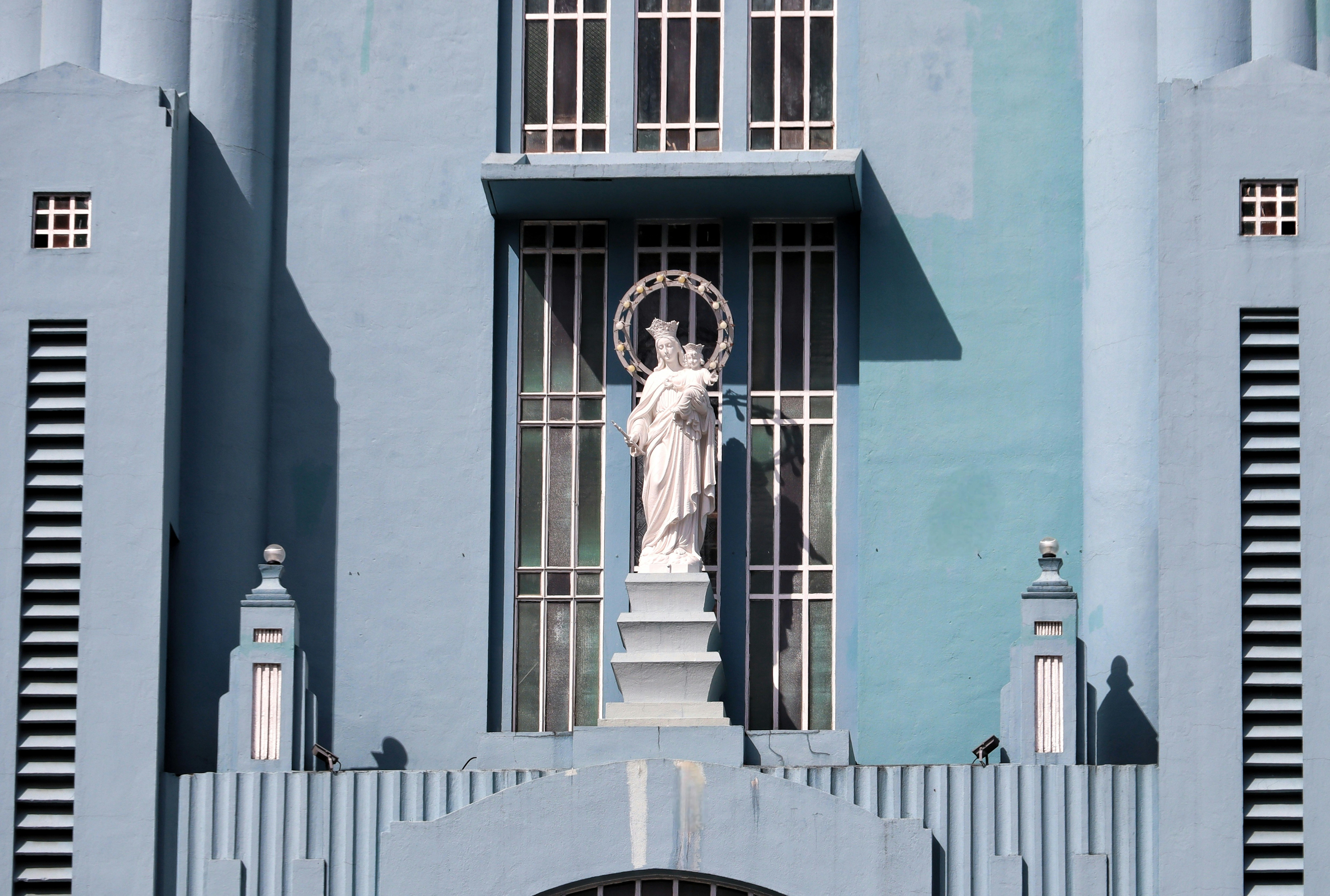 A blue building with a statue in the window photo – Free Emotions Image ...