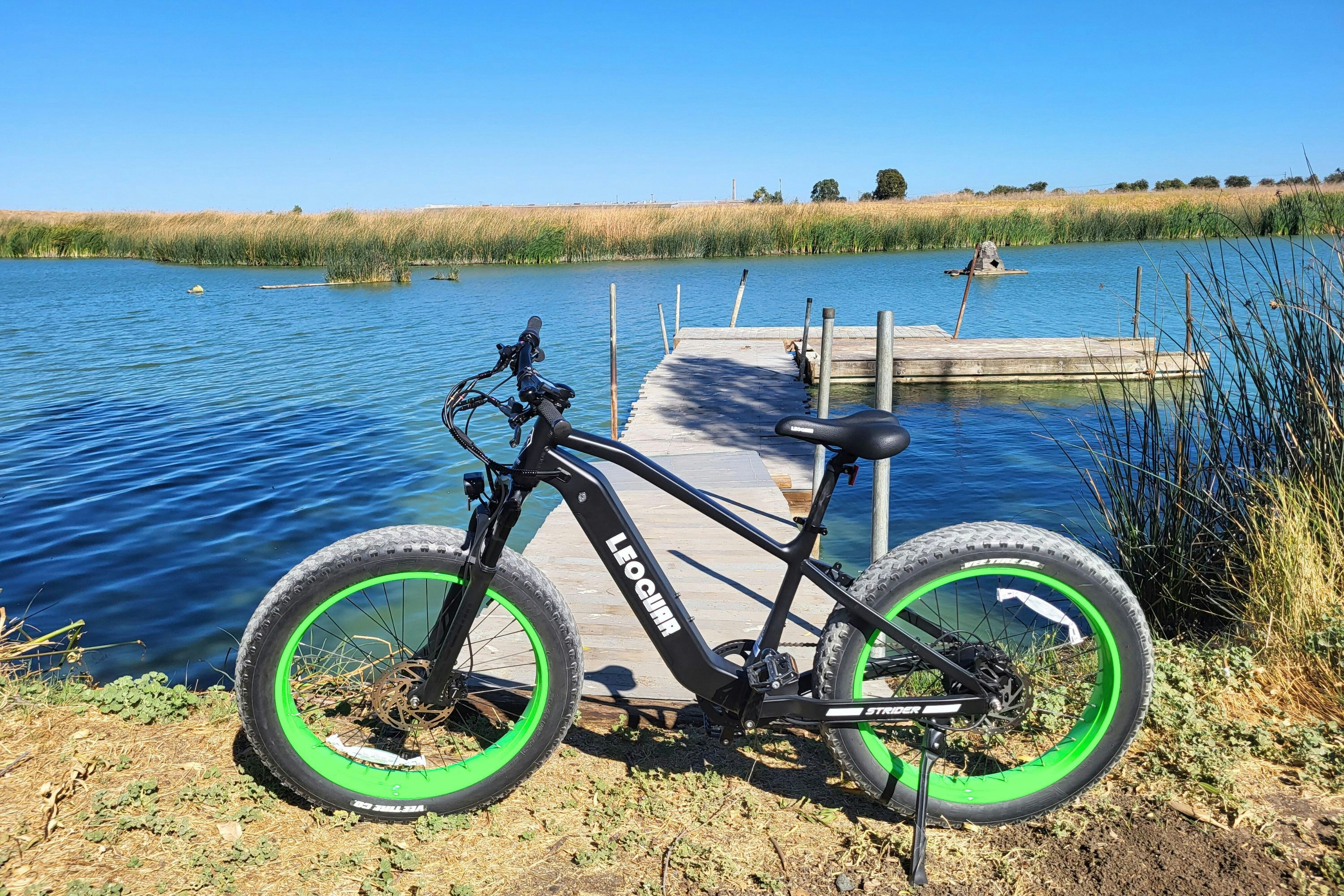 A bike parked on a dock next to a body of water photo – Free Bike Image ...