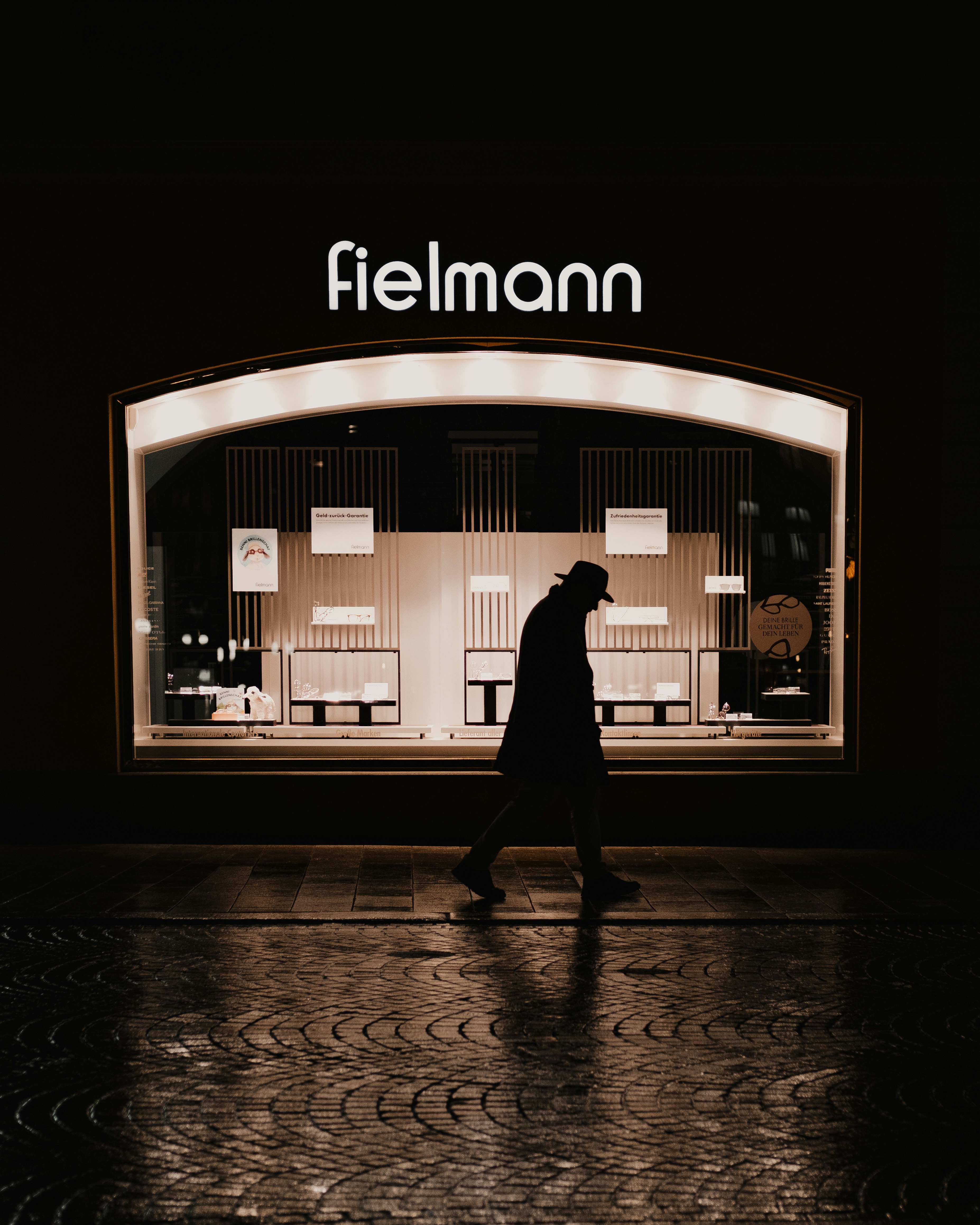 A man walking past a store front at night photo – Free Leipzig Image on ...