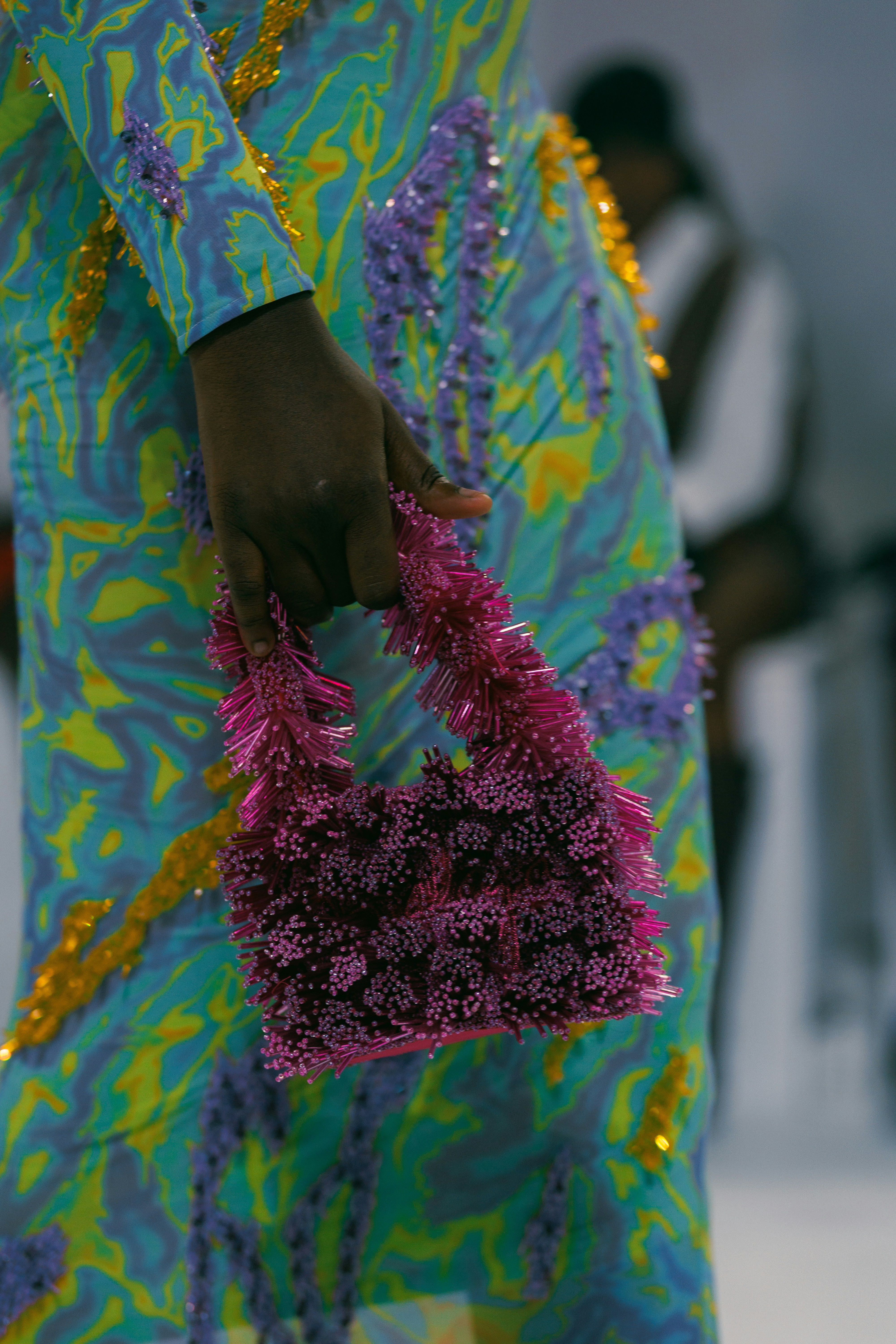 Beaded Magenta Clutch Amid Neon Silk: A Fashion Moment