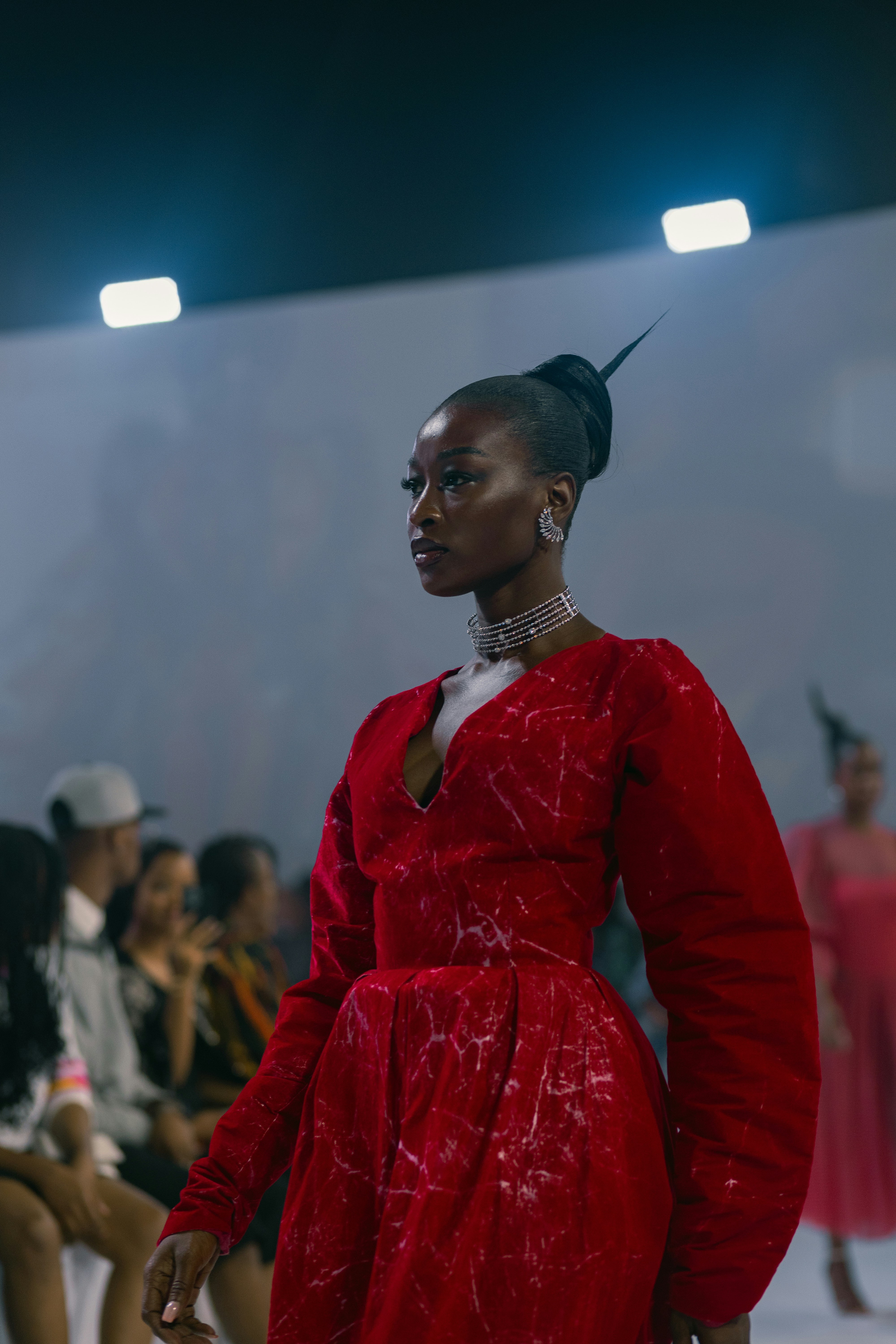 A woman in a red dress standing in front of a crowd photo – Free Lagos ...