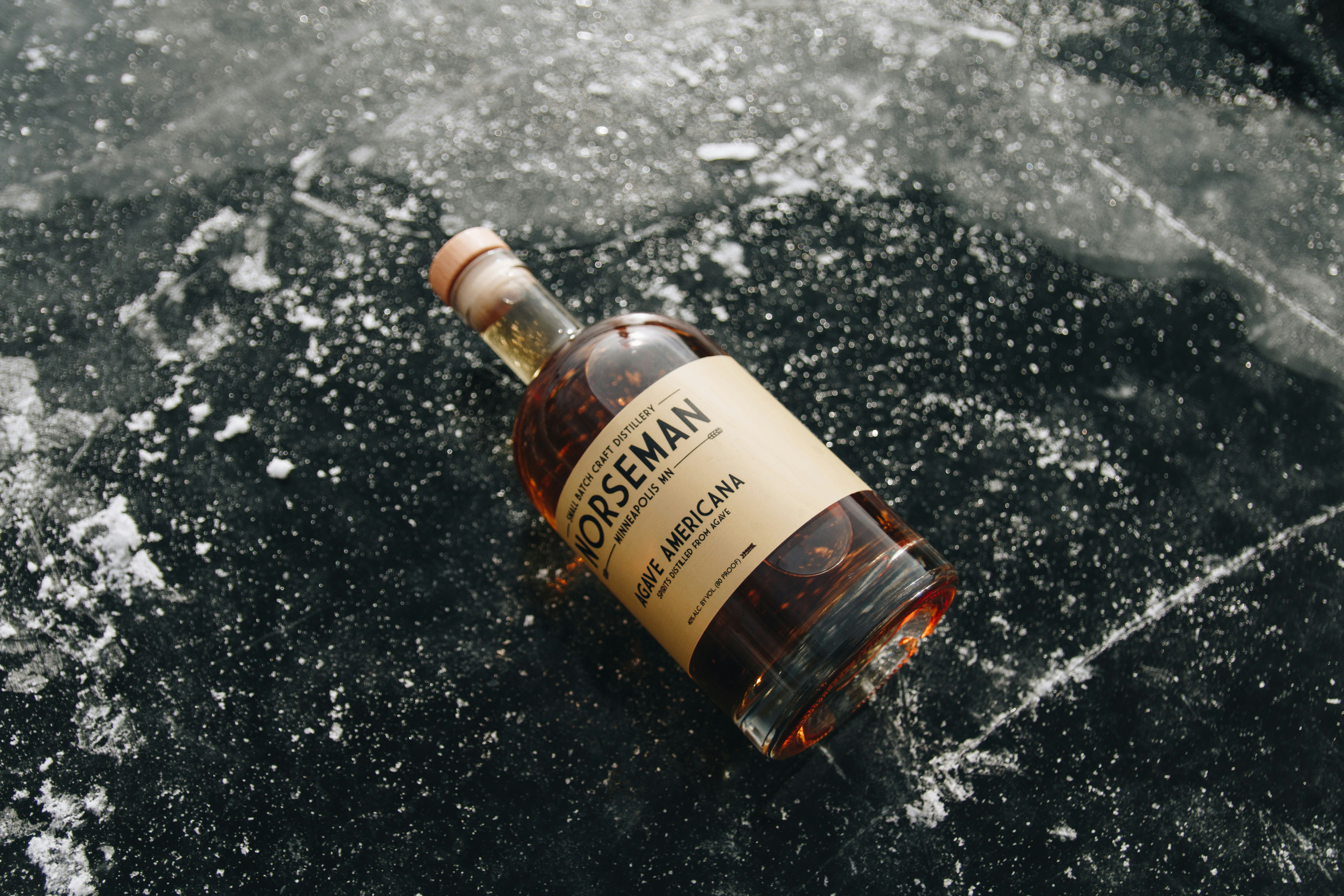 Amber on Ice: A Whiskey Bottle Resting on Frosty Slate