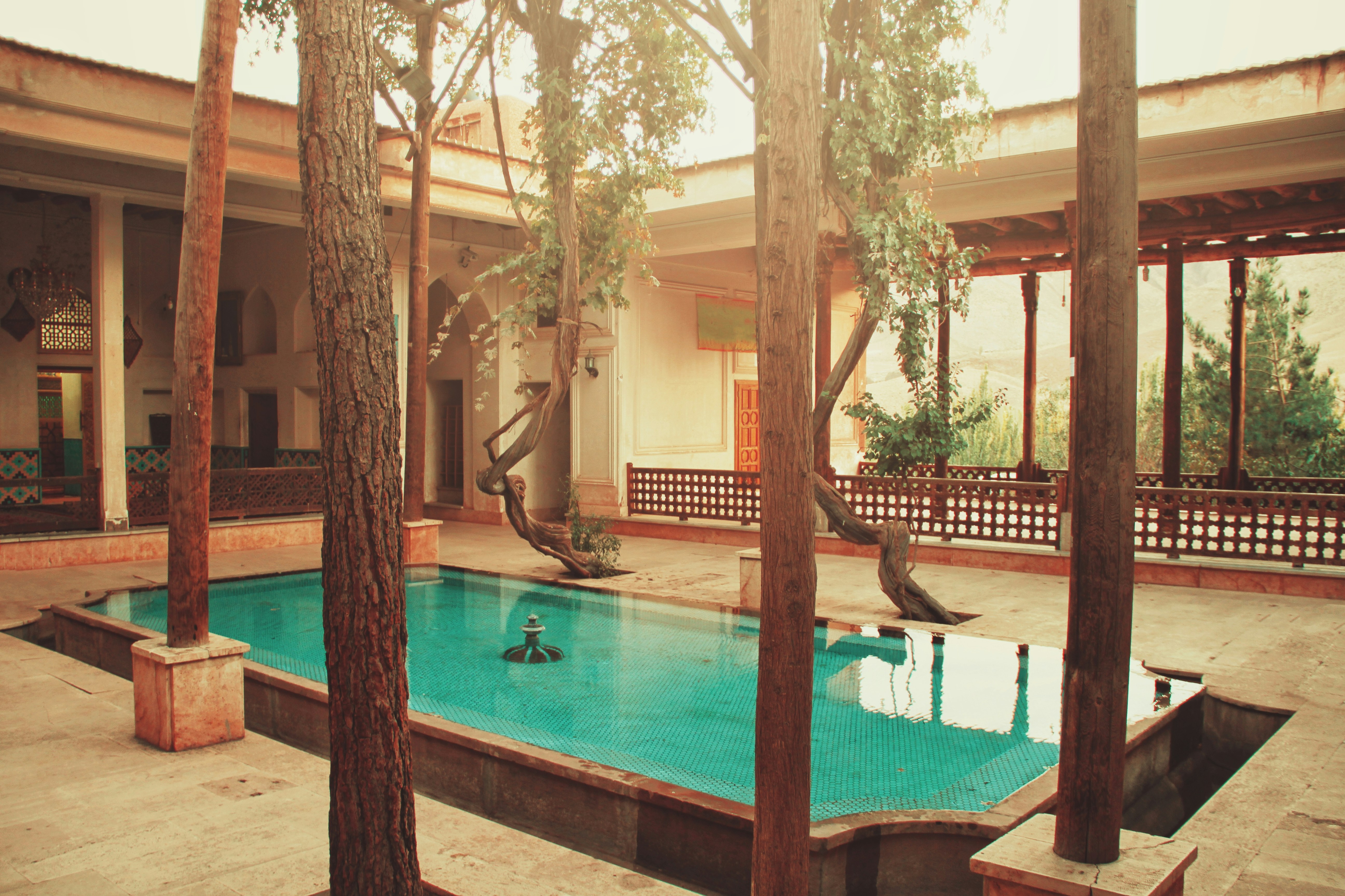A pool surrounded by trees in a courtyard photo – Free Hotel Image on ...