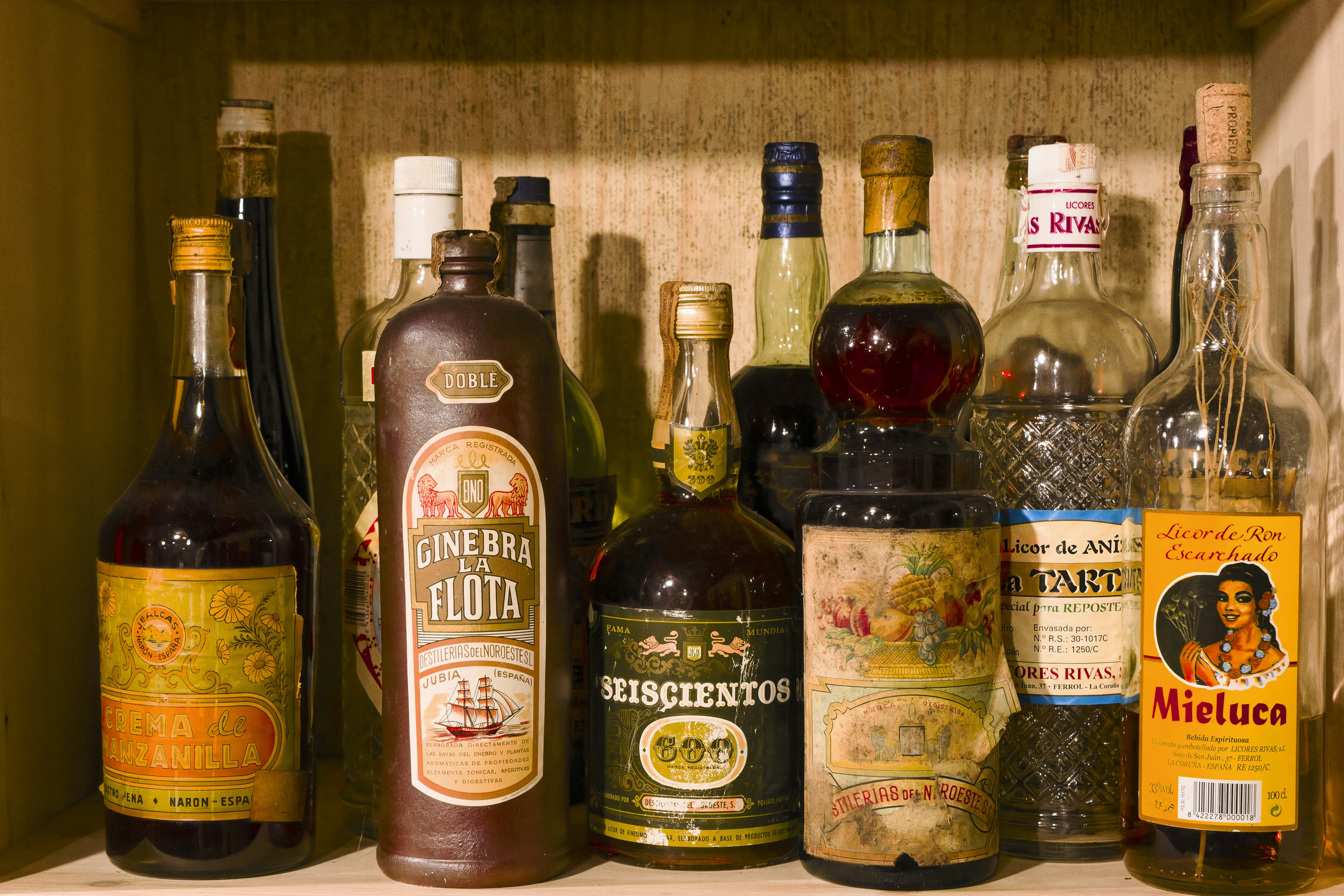 A shelf filled with bottles of different types of liquor photo – Free ...