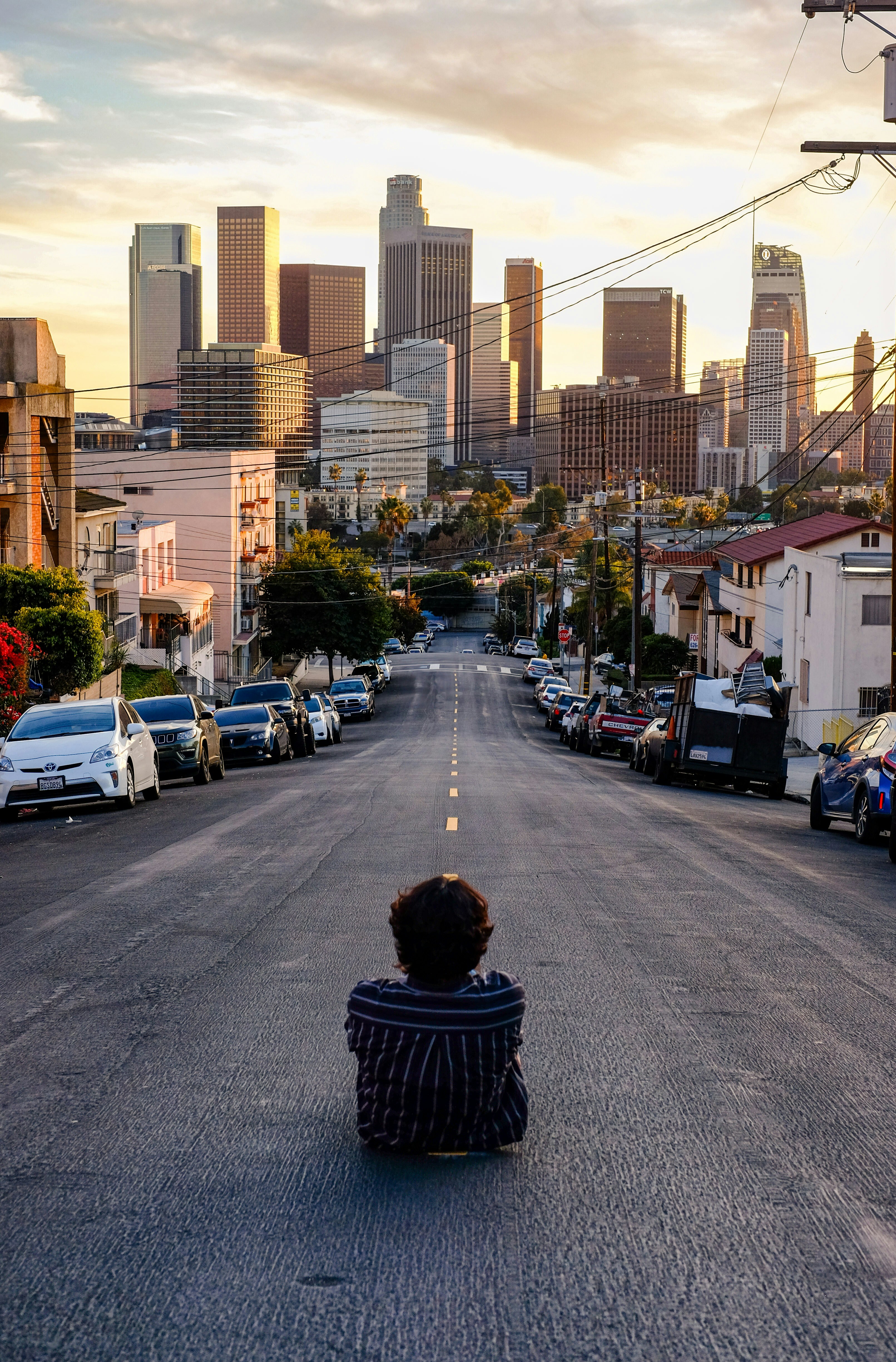 Downhill to the City: A Child’s Quiet Descent from a Sunset Hill