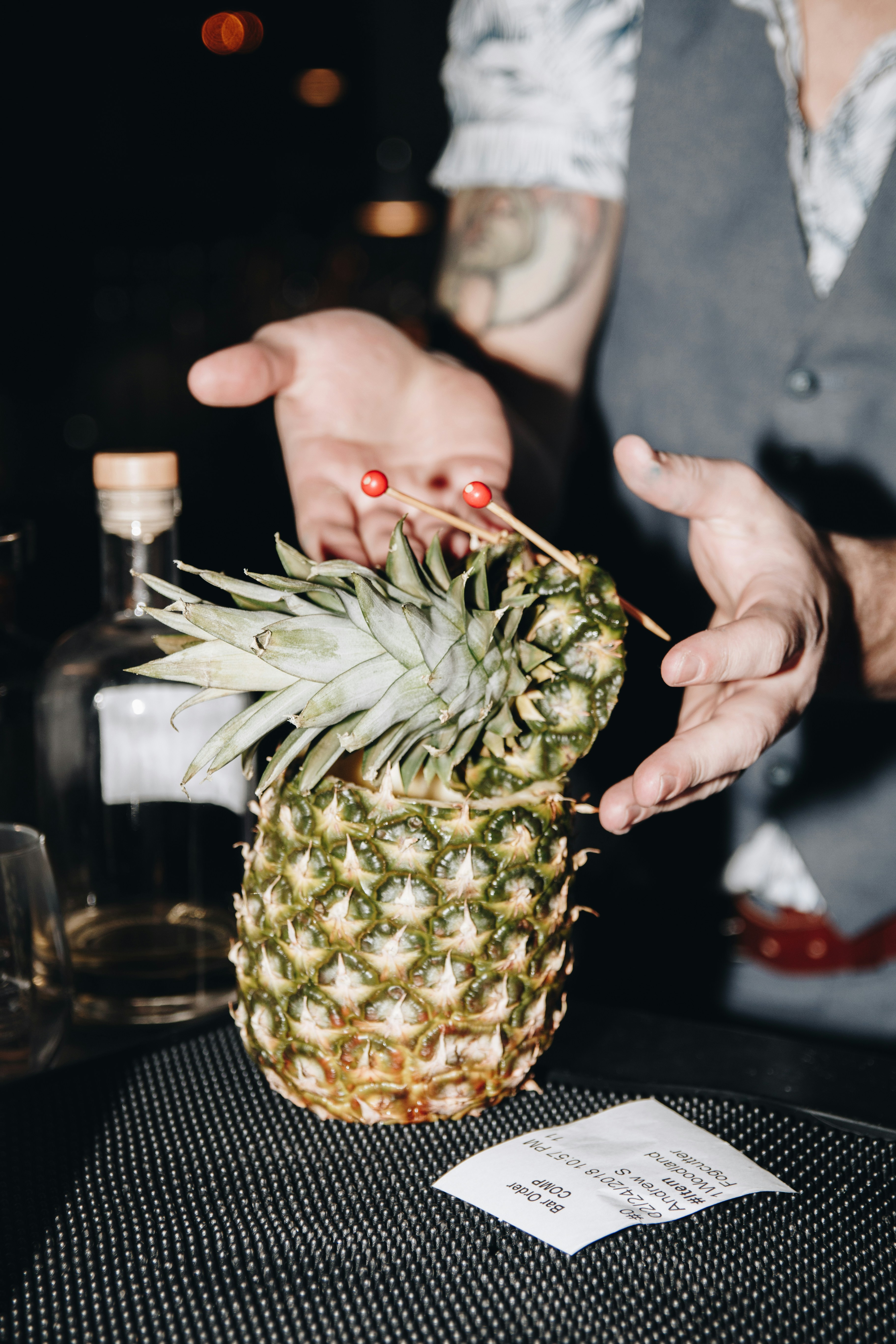 Garnish Ritual: Hands Hover Over a Pineapple Crown