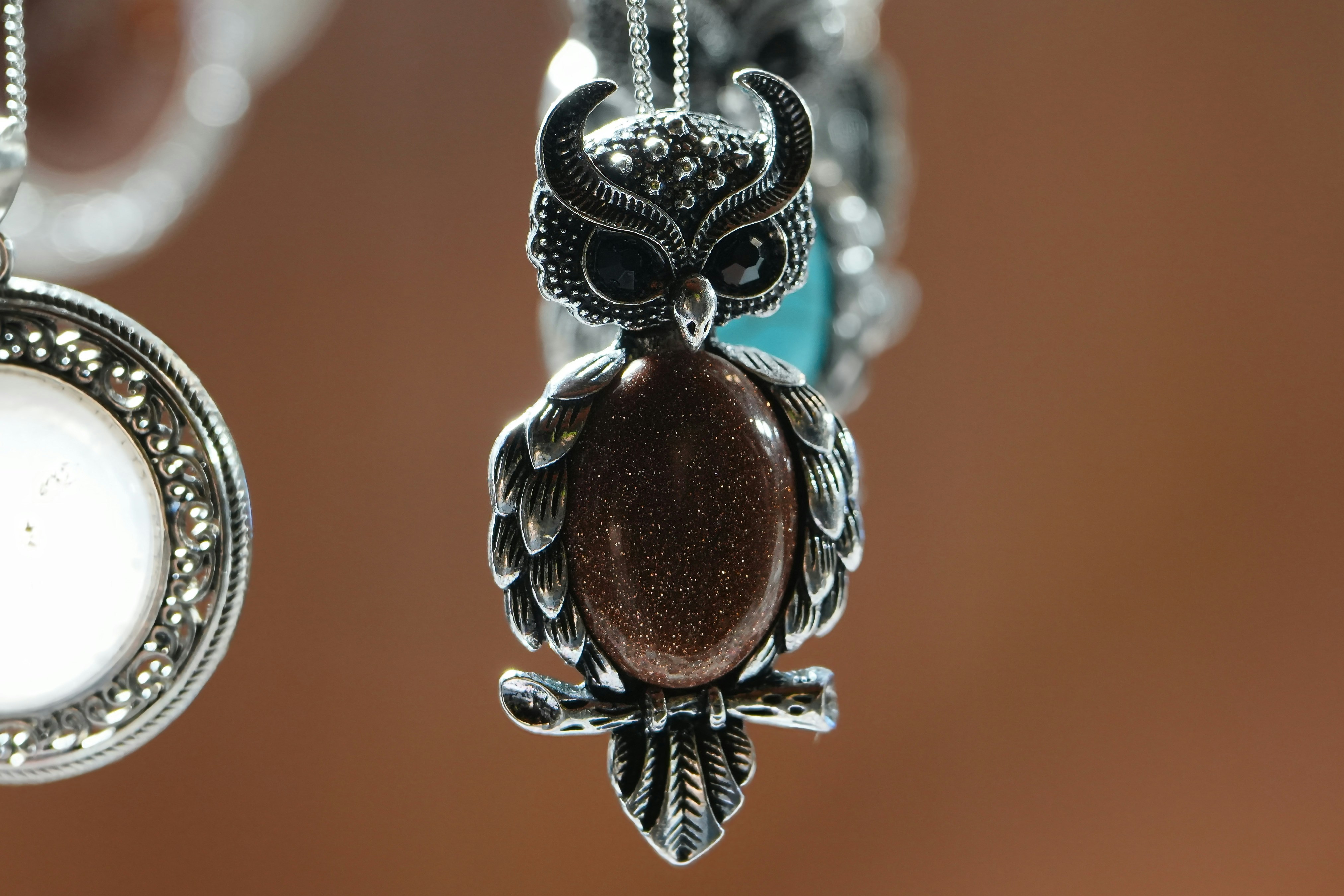 Owl Guardian Pendant: Intricate Silver Carving Framing a Chestnut Gem