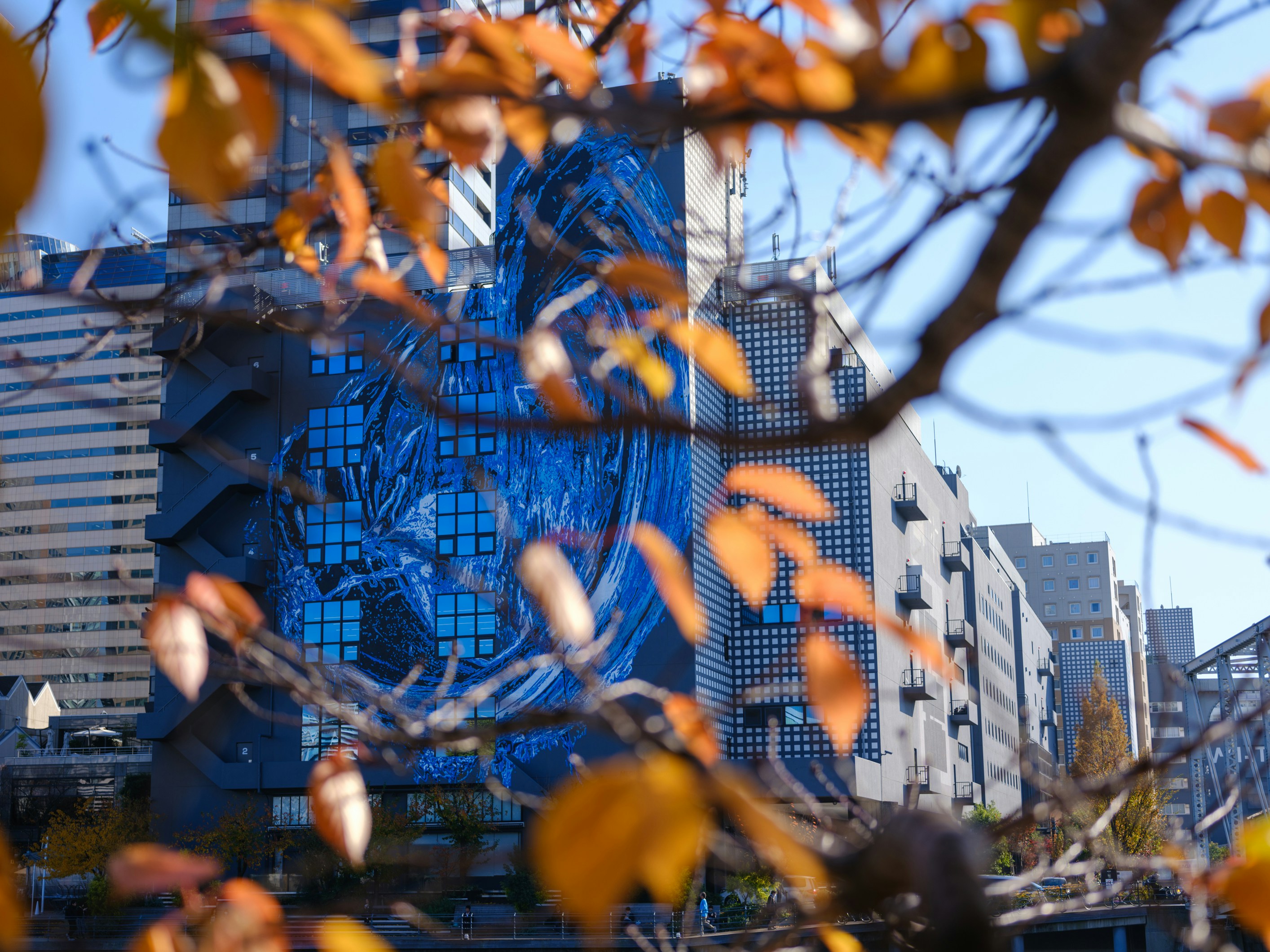 City Facade in Focus: Blue Mosaic Among Fallback Foliage