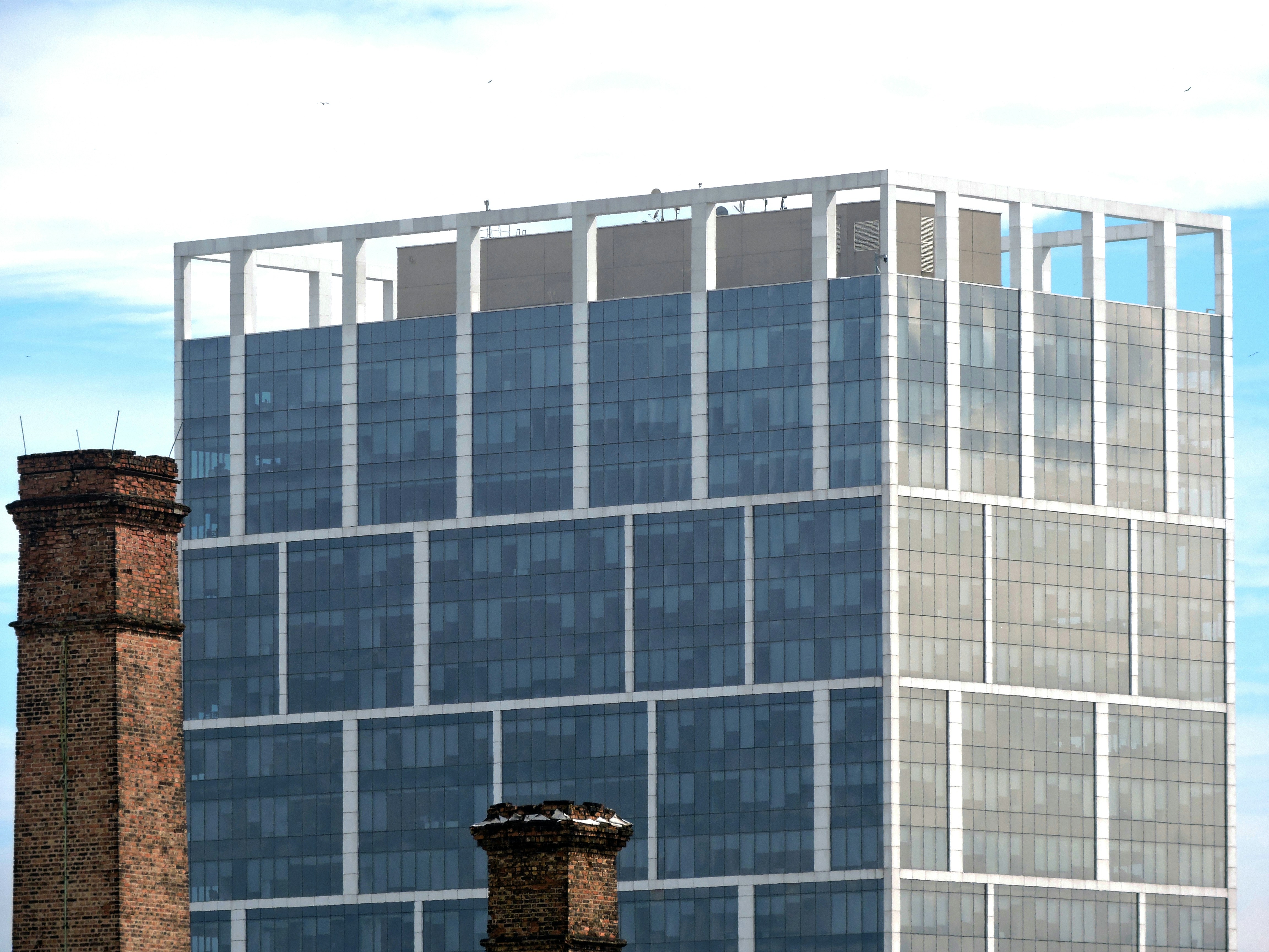 Modern high-rise with a grid-like facade set against a clear sky.