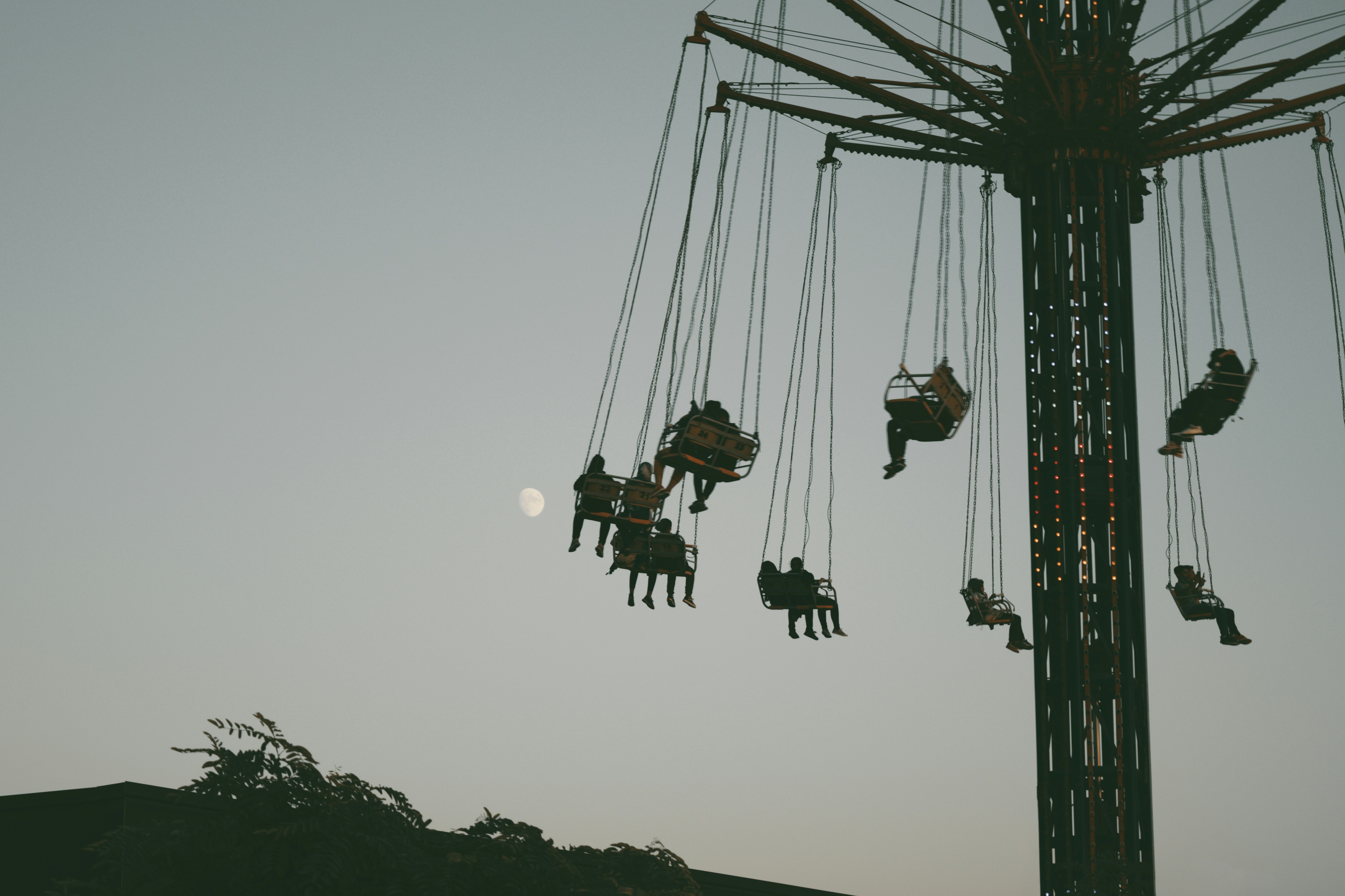 A group of people riding on top of a carnival ride photo – Free Calm ...