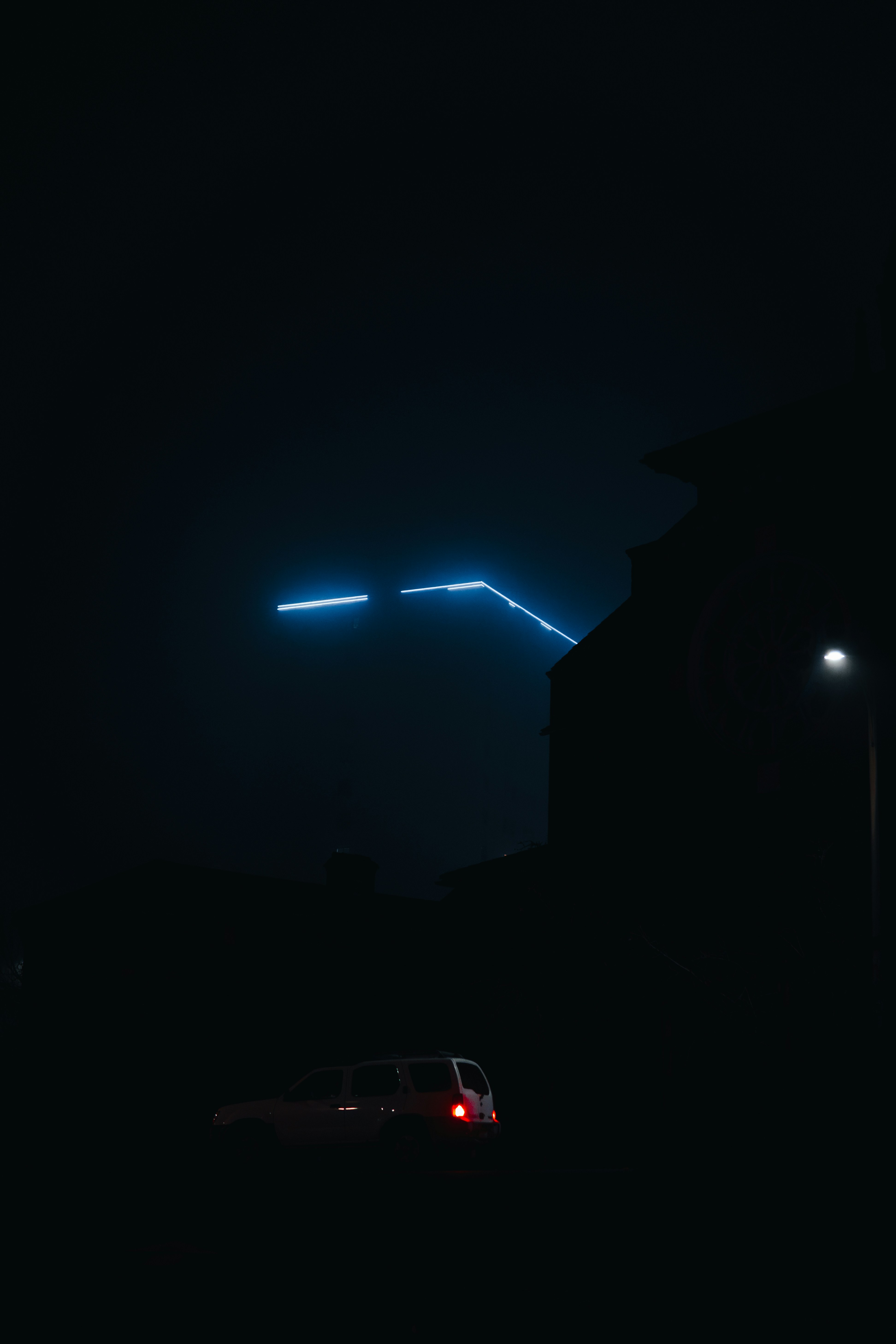 Blue Neon Zigzag Above a Silhouetted Night Street