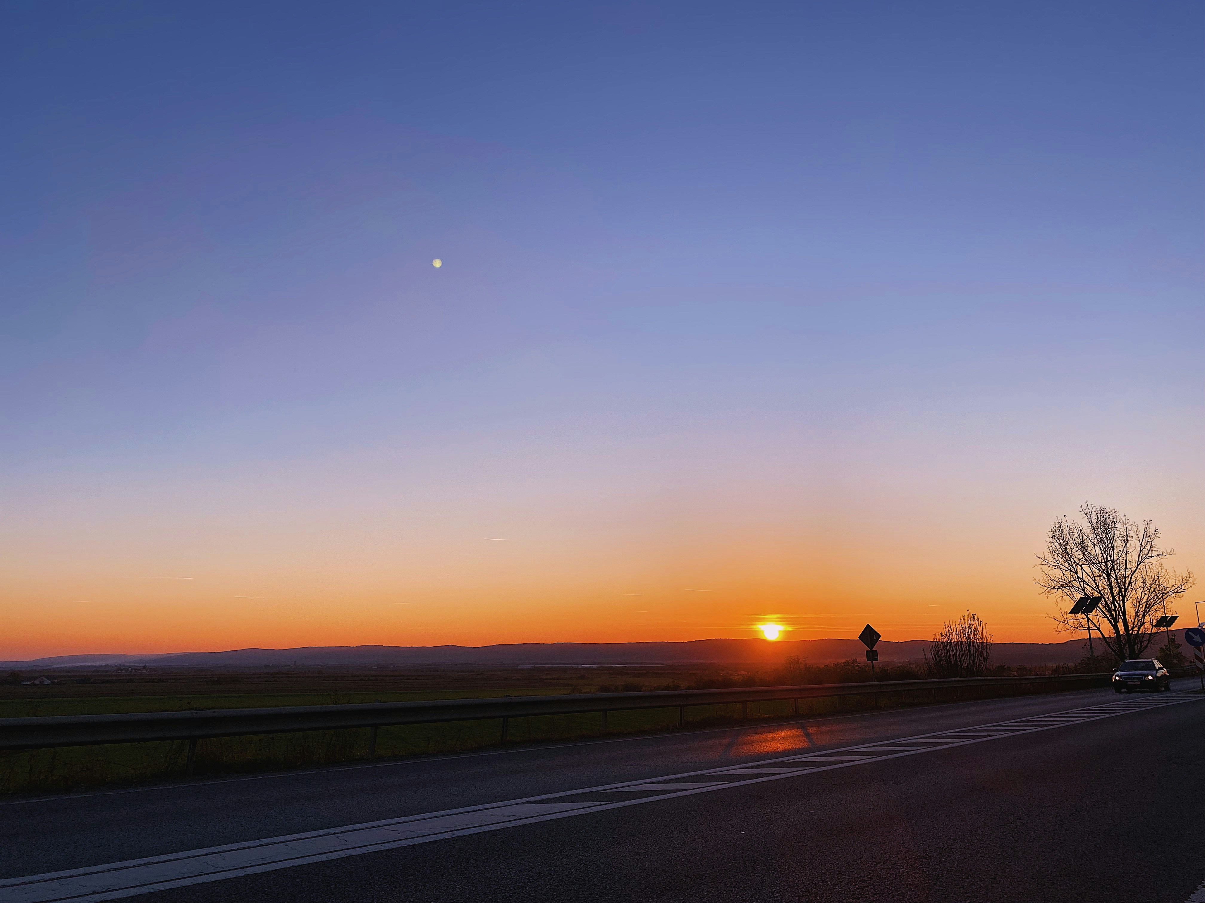 Horizon's Quiet Arc: Sunset Road Under a Moonlit Sky