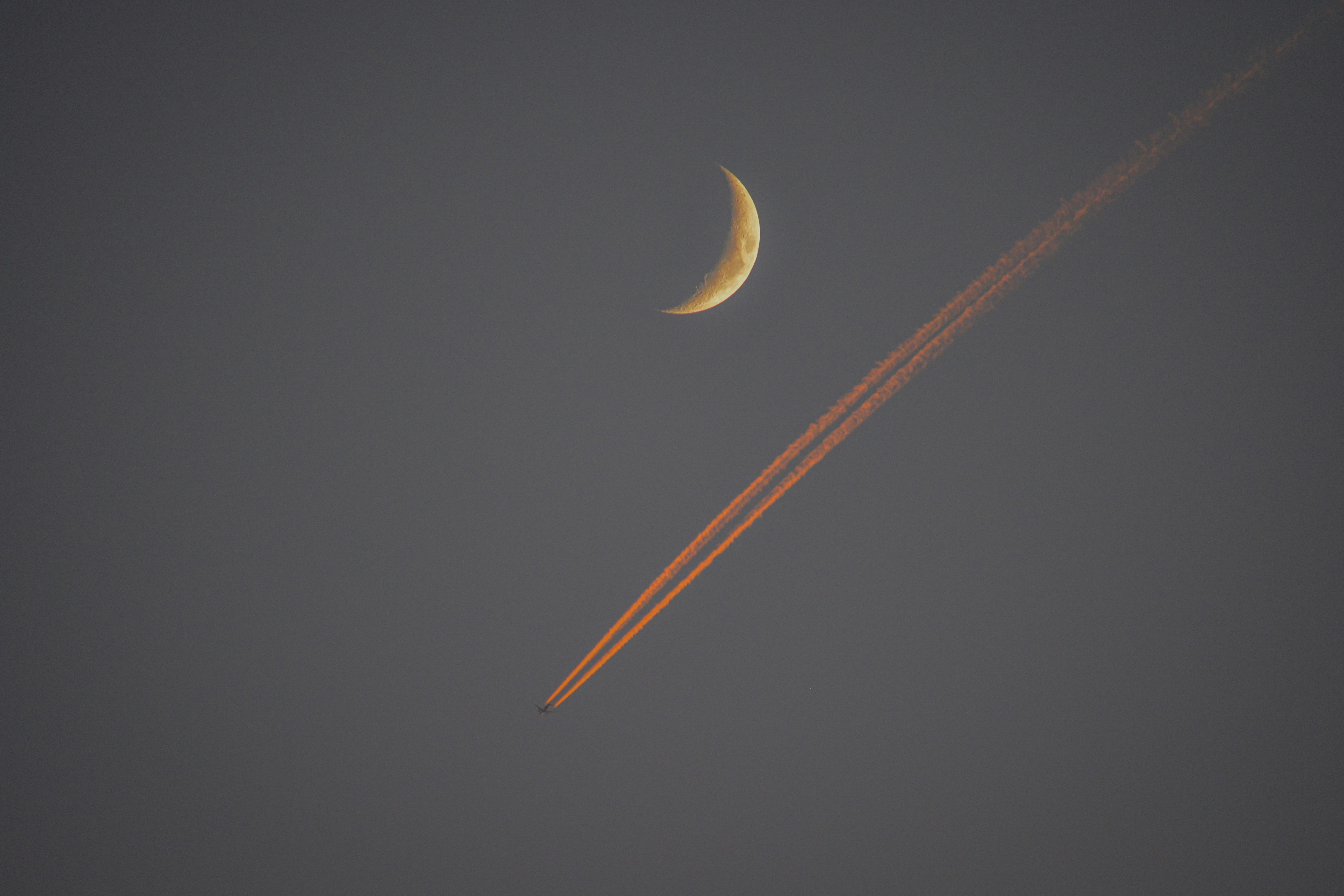 A plane flying in the sky with the moon in the background photo – Free ...