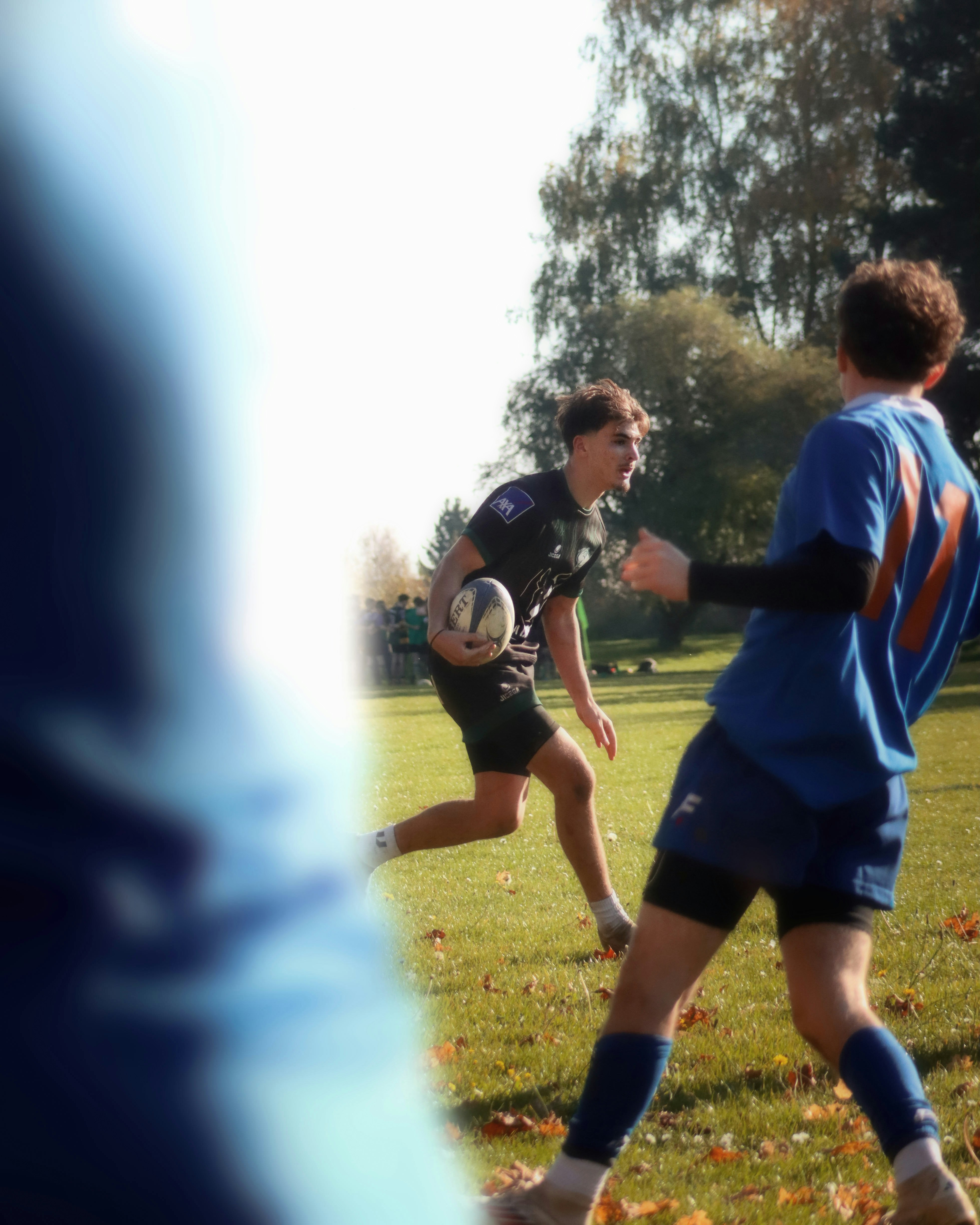 Midfield Sprint: Ball Carrier Evades Defenders on a Sunlit Rugby Field