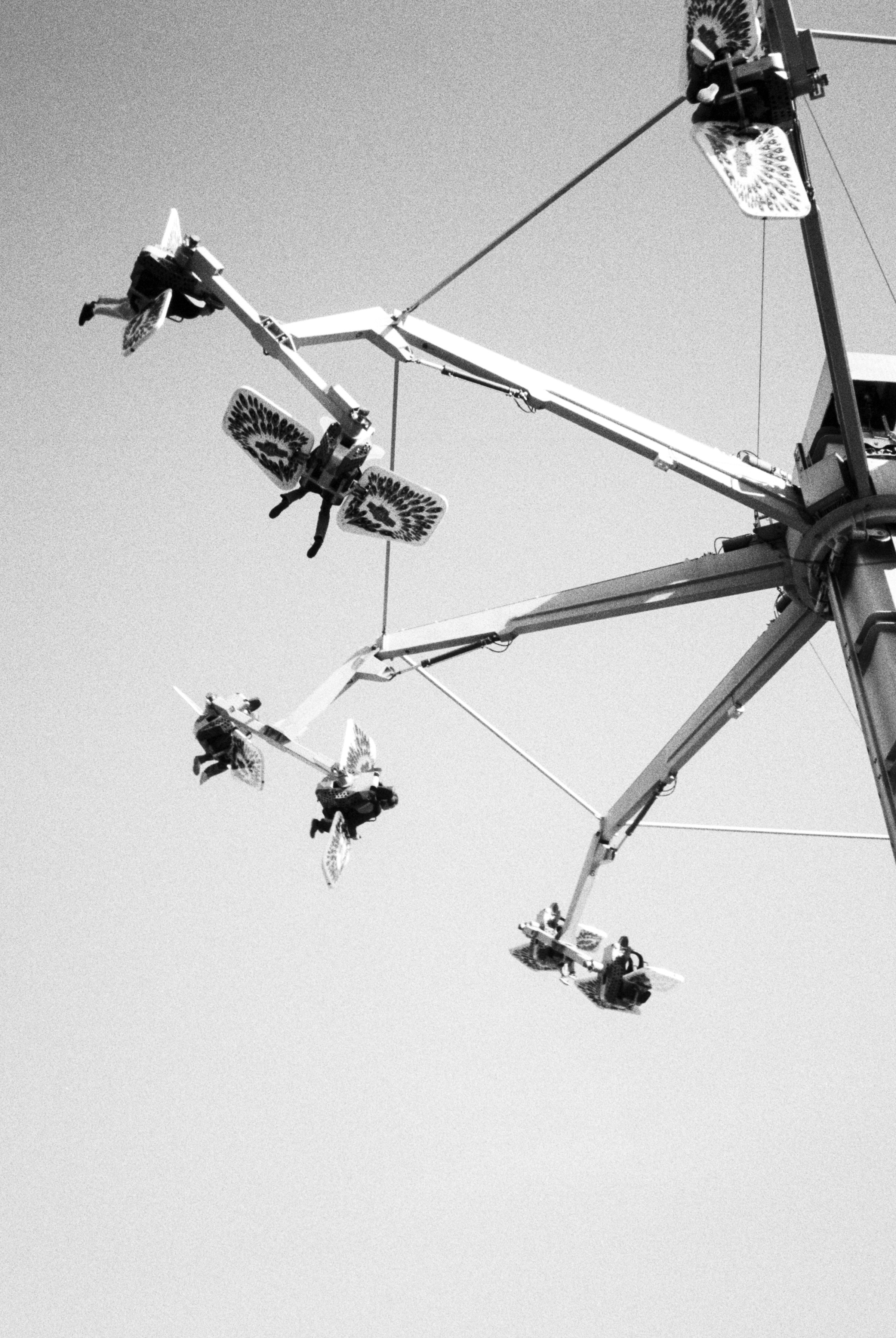 Iron Whirl: Riders Swing in a Monochrome Sky