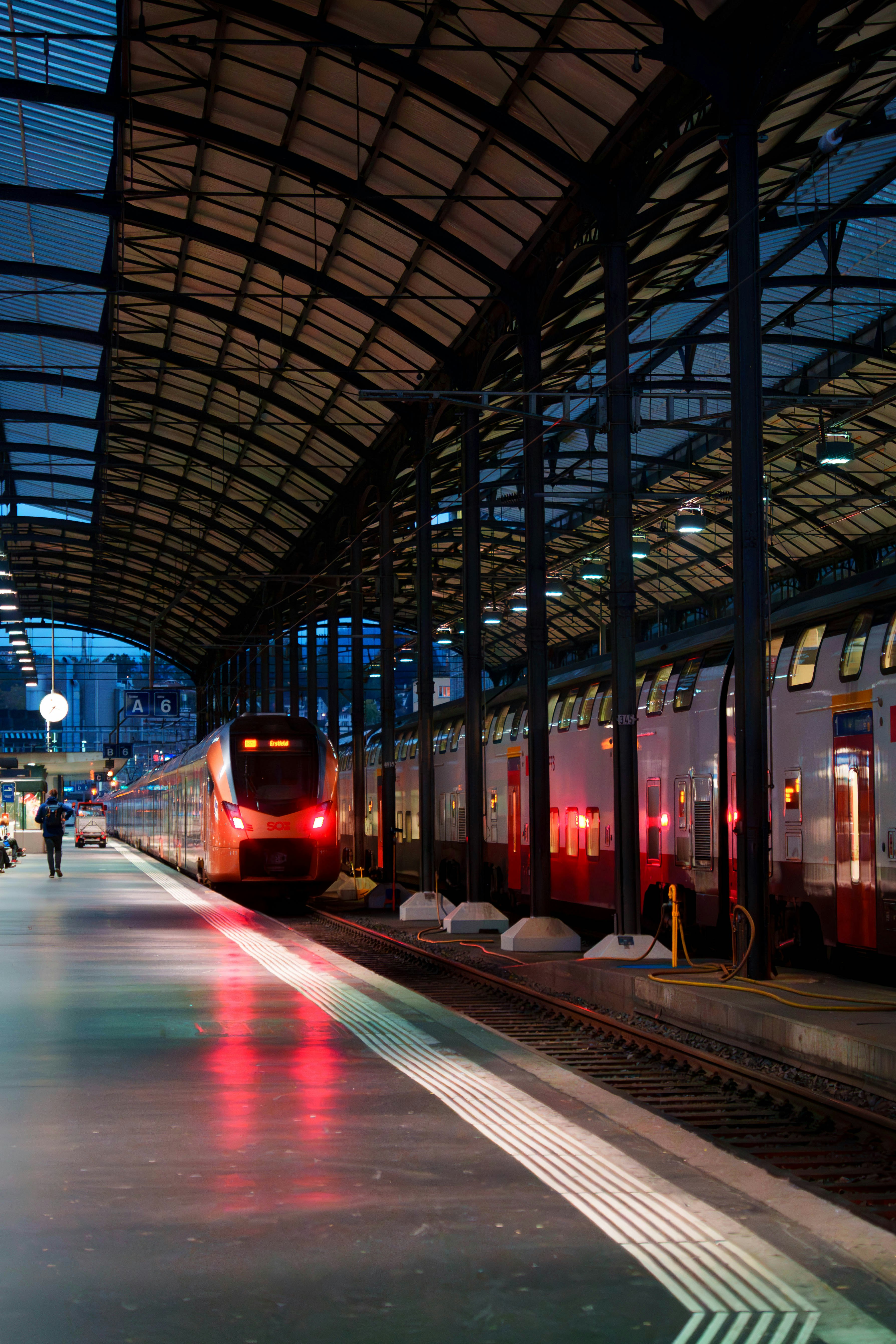A train pulling into a train station next to a platform photo – Free ...