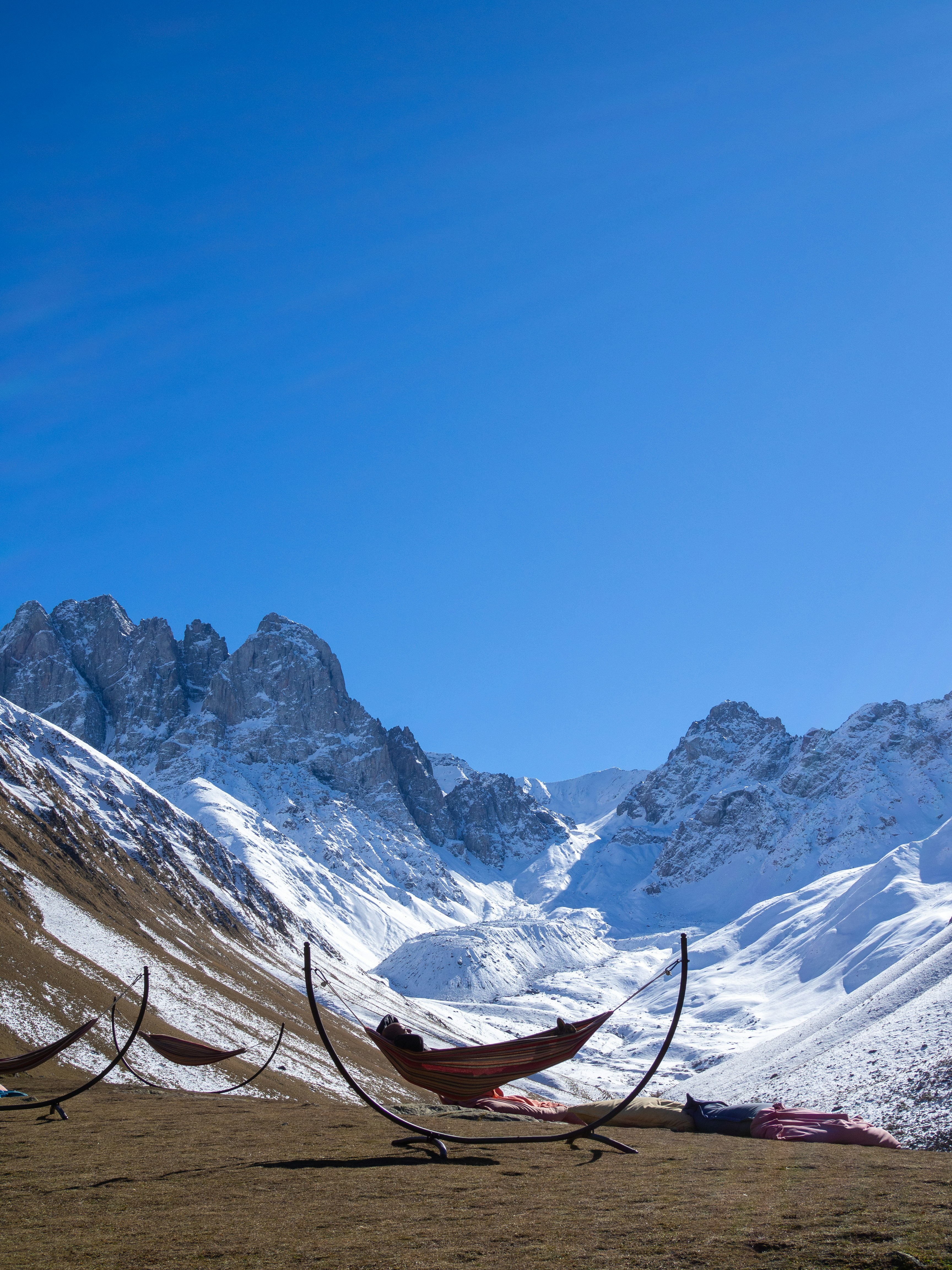 A couple of hammocks sitting on top of a grass covered field