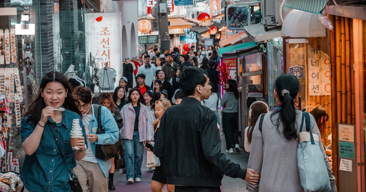 한 무리의 사람들이 고층 건물 옆 거리를 걷고 있다 사진 Unsplash의 무료 시울 이미지