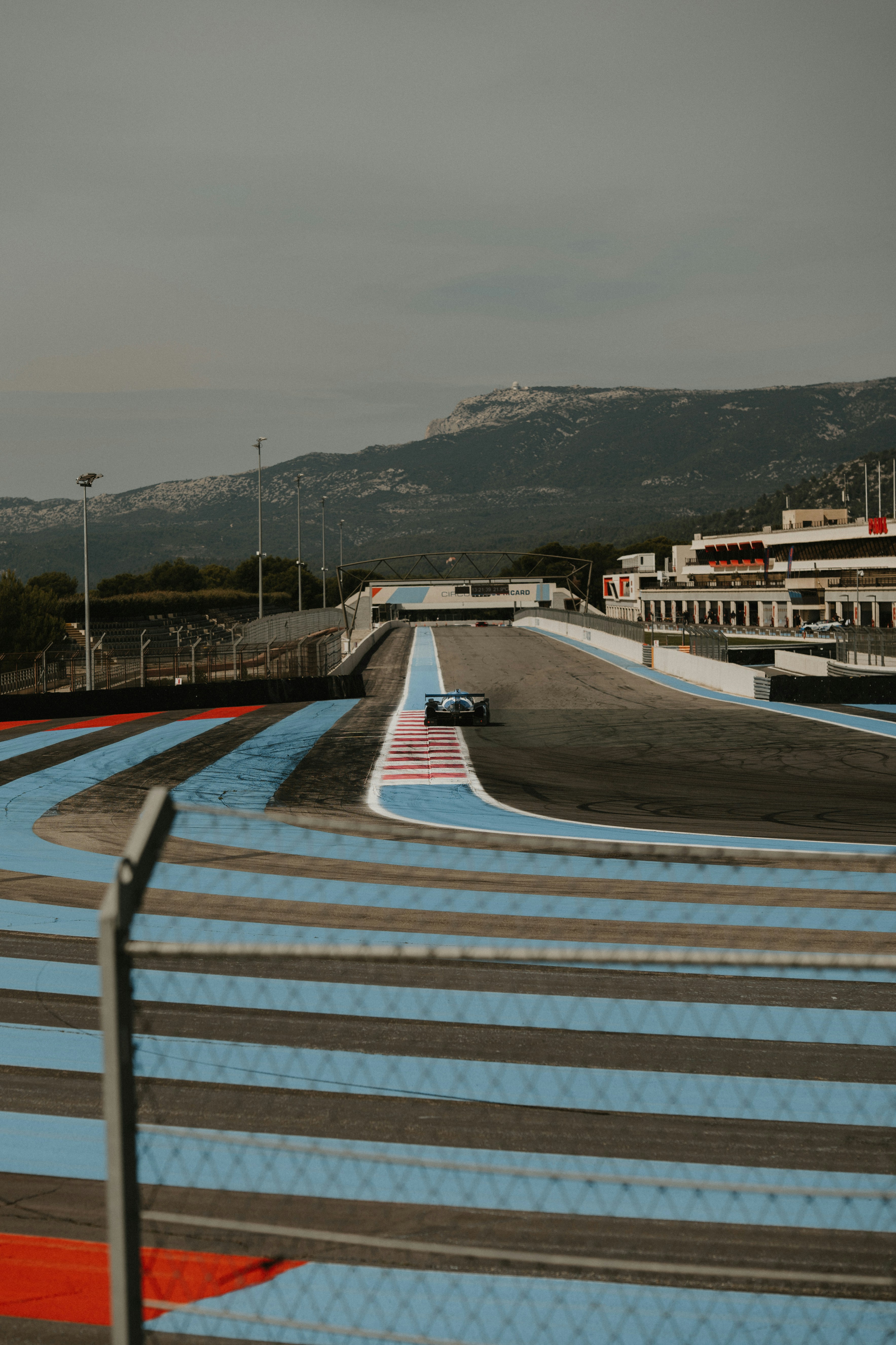 Raceway in Focus: Car Cresting the Blue-Kissed Turn