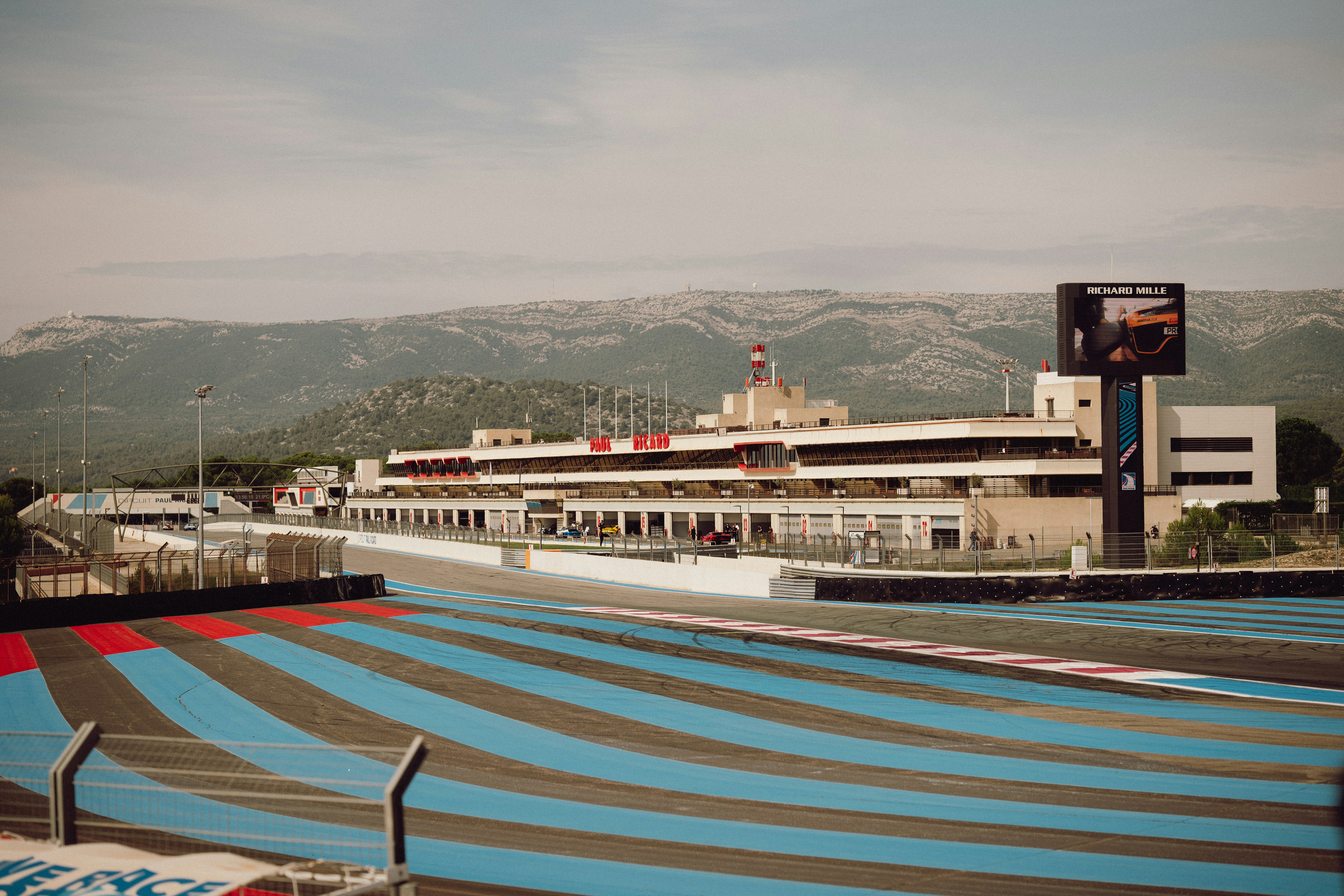 A race track with a large building in the background photo – Free Track ...