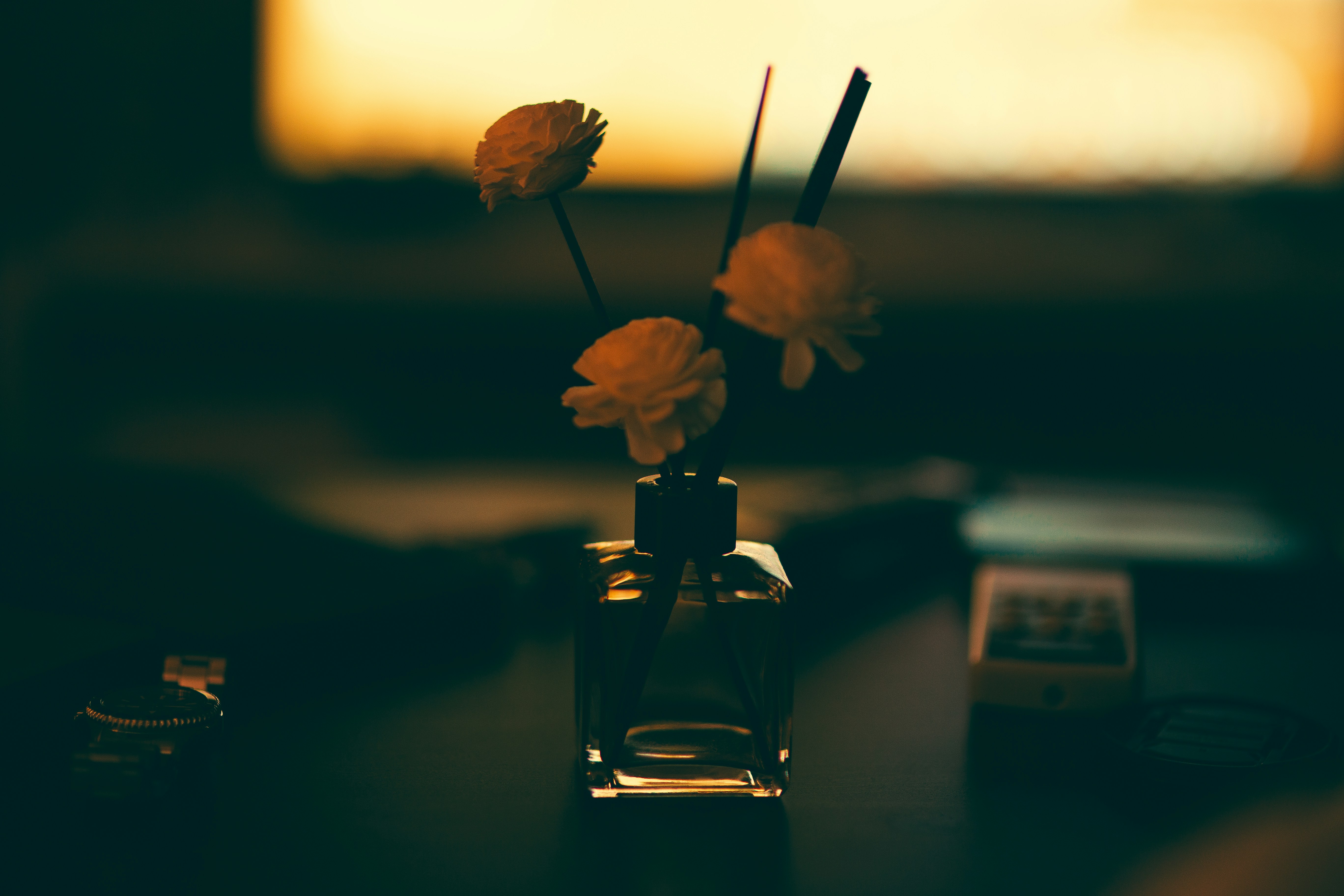 Amber Backlight Still Life: A Glass Vial Cradling Dried Blossoms