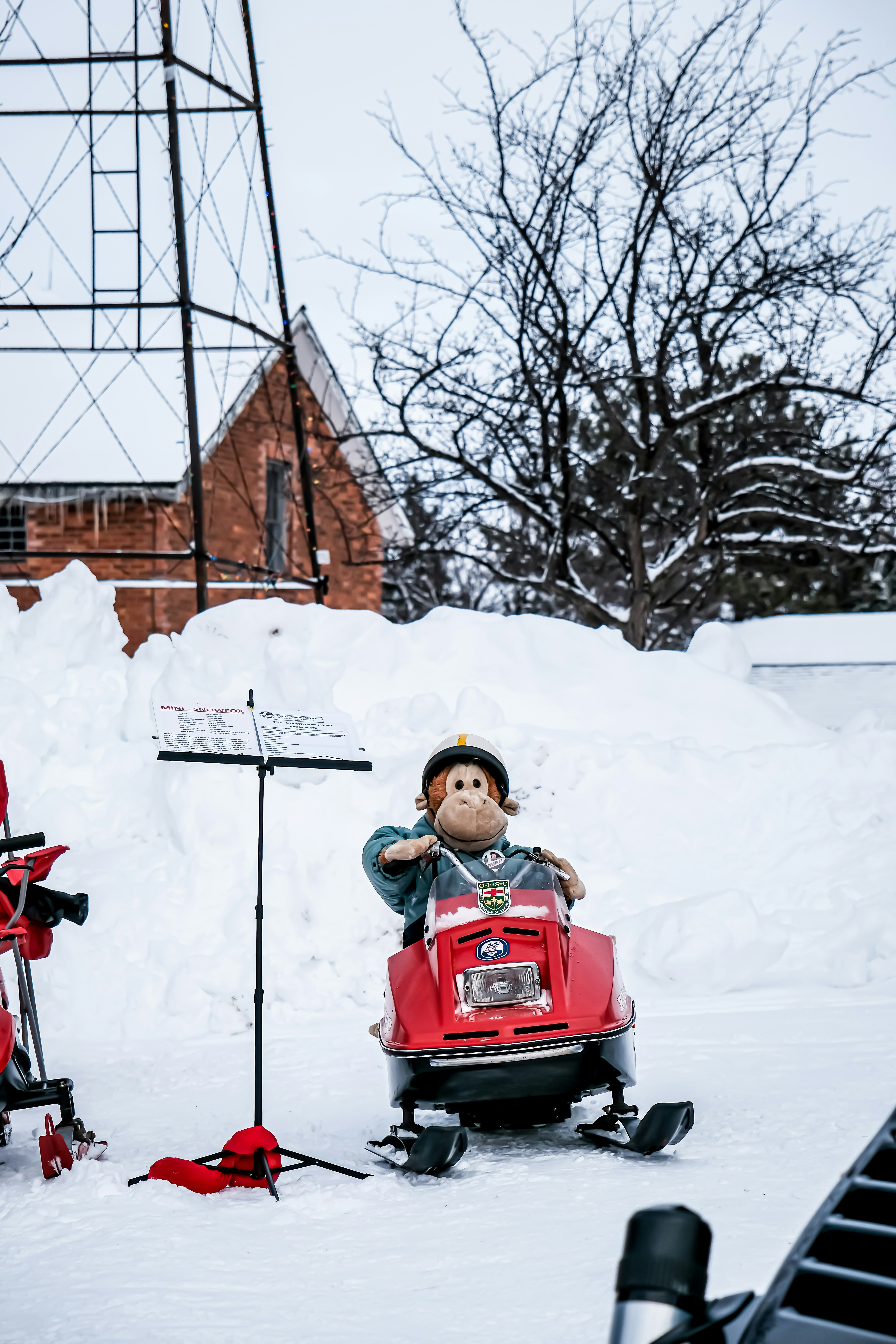 A couple of people riding on top of a sled down a snow covered slope ...