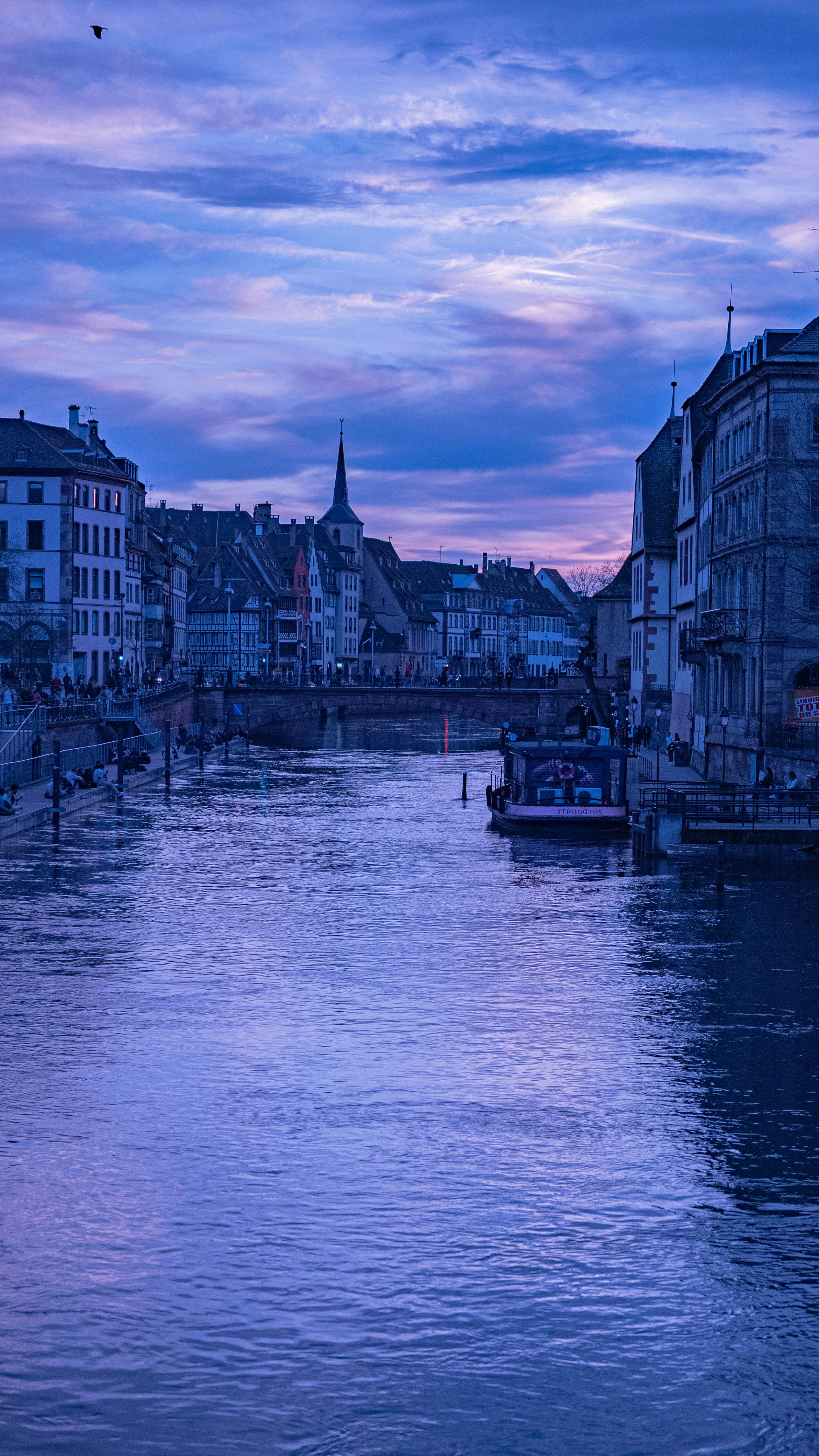 Violet Hour Over a Canal Town: Spire, Brick Facades, and Quiet Water Reflections